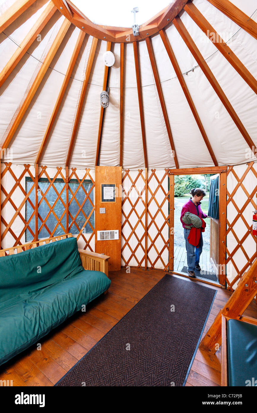 Woman carrying camping gear through doorway of rental yurt at Kayak ...