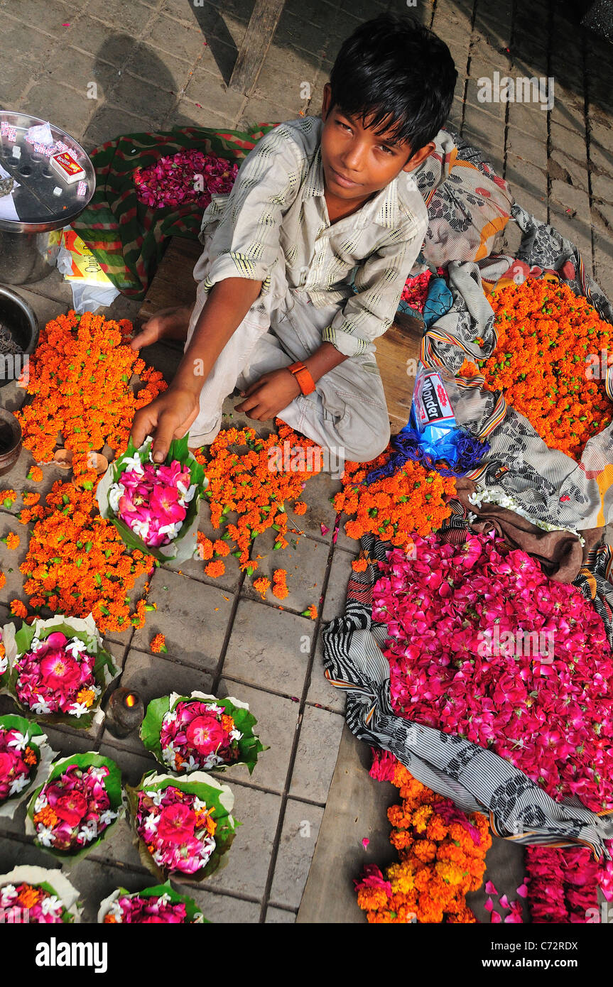 Young boy selling flowers to the pilgrims for the devotion to the God ...