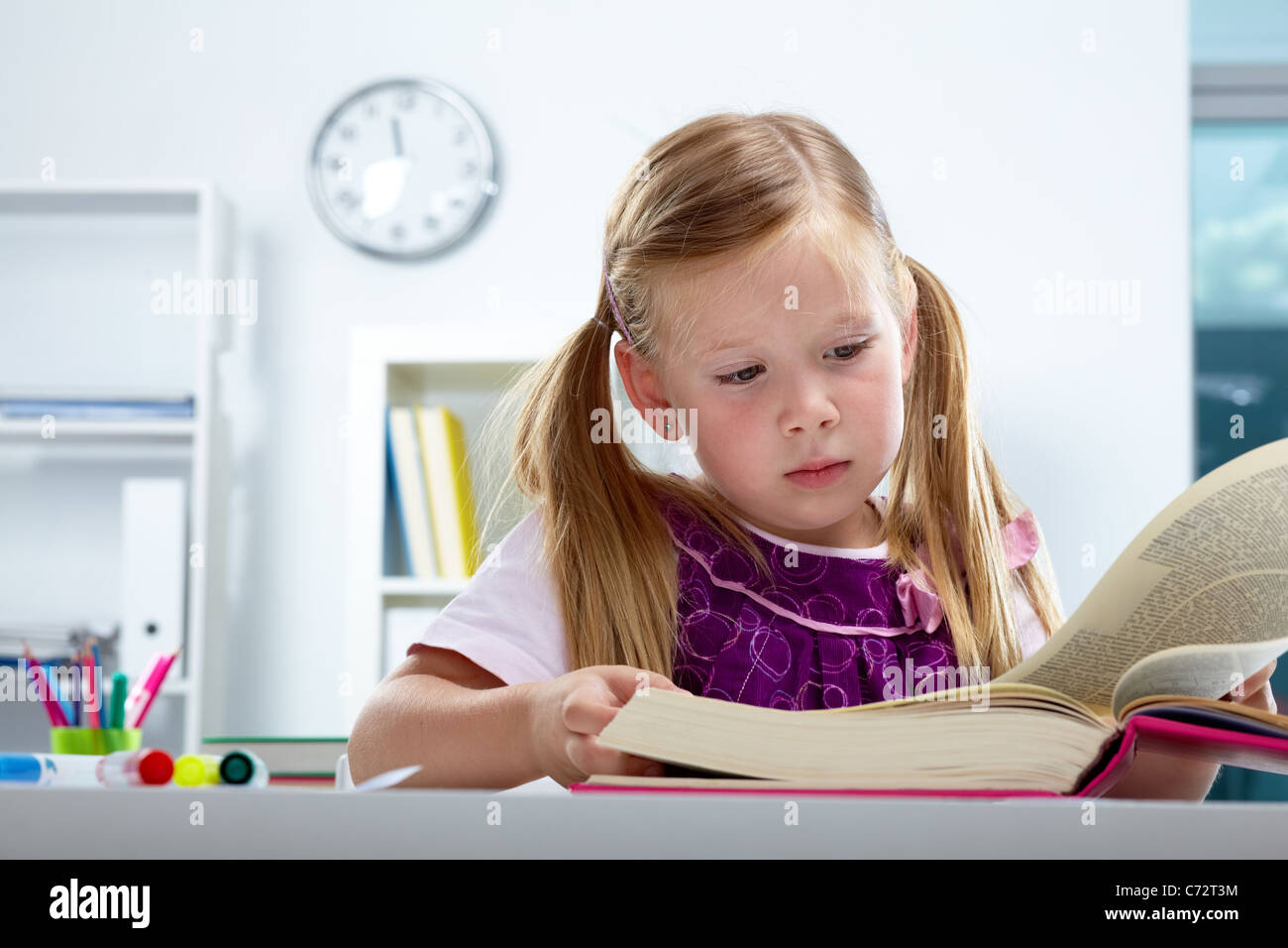Portrait of lovely girl reading big book in library Stock Photo - Alamy