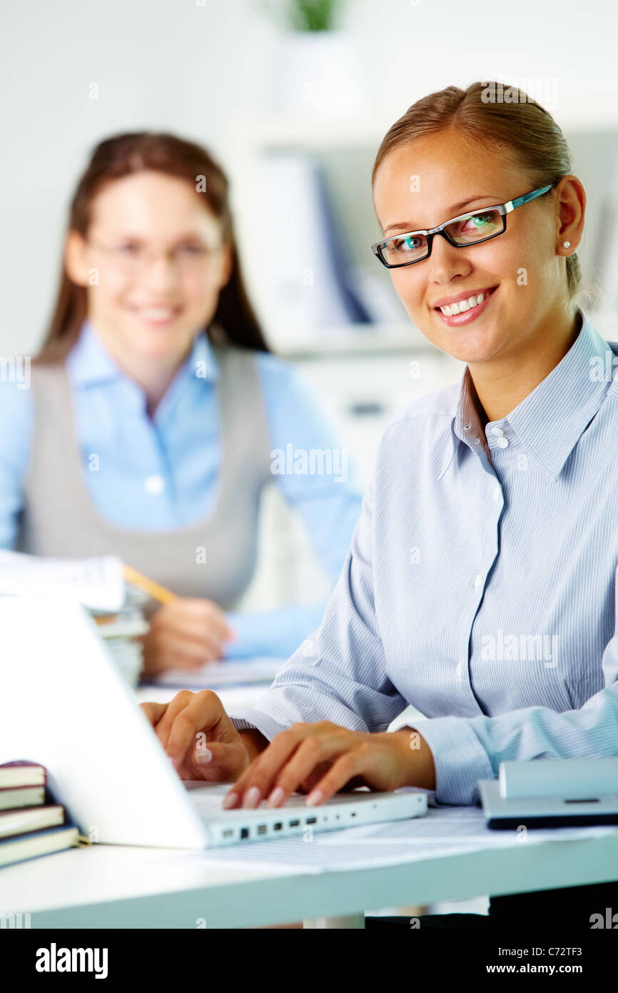 Portrait of pretty secretary looking at camera in working environment ...