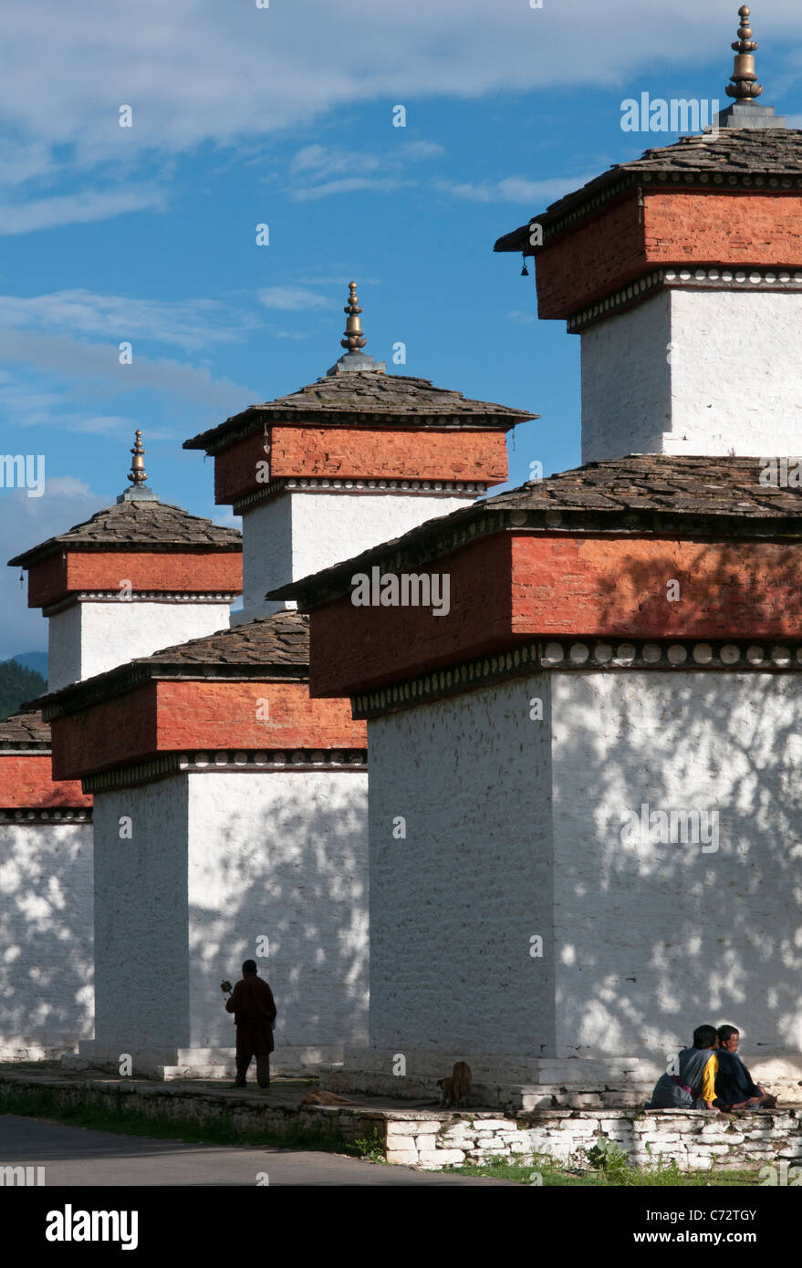 man walking chora around triple chorten with prayer drum. paro. bhutan ...