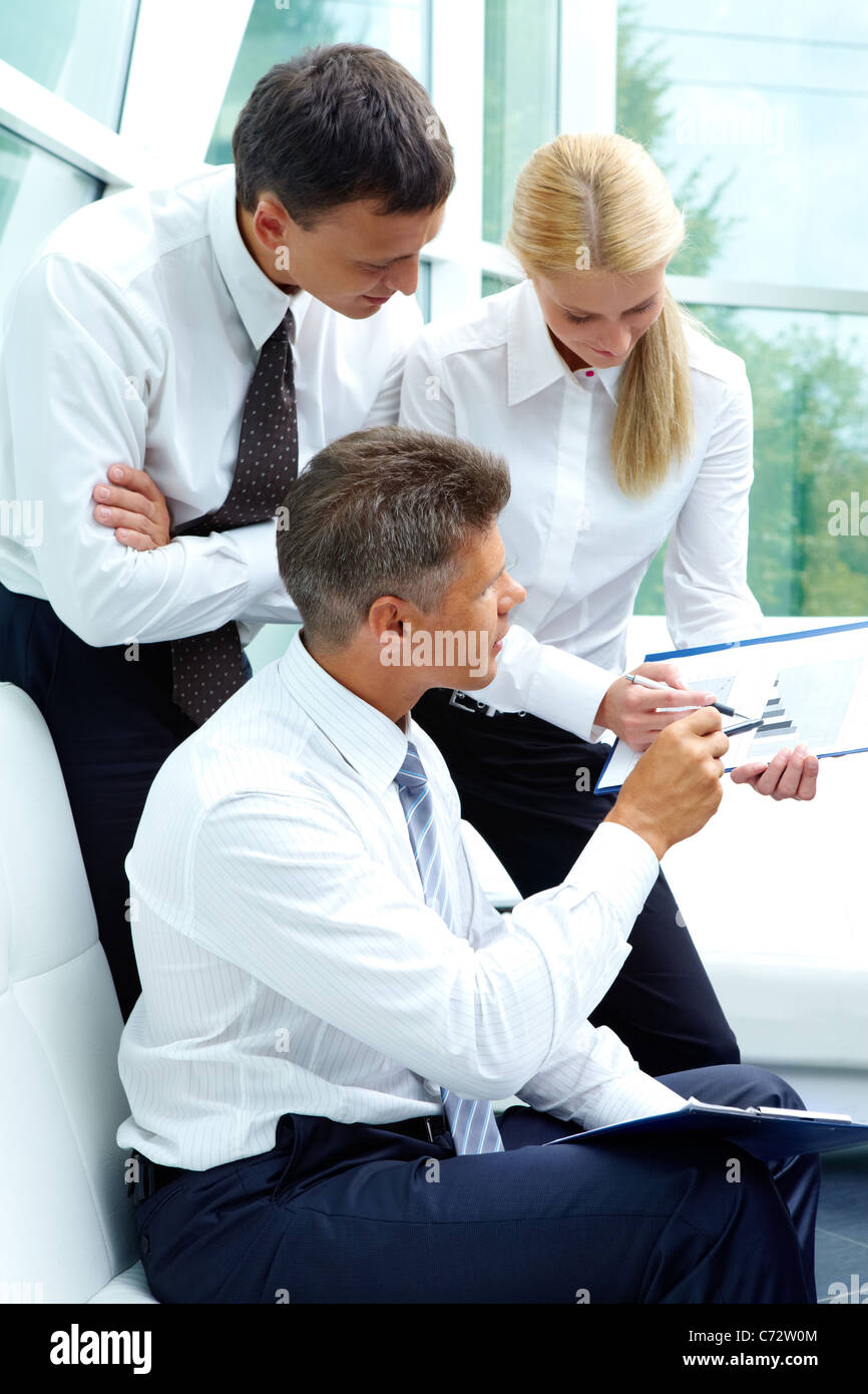 Photo of successful employees discussing papers at meeting Stock Photo ...