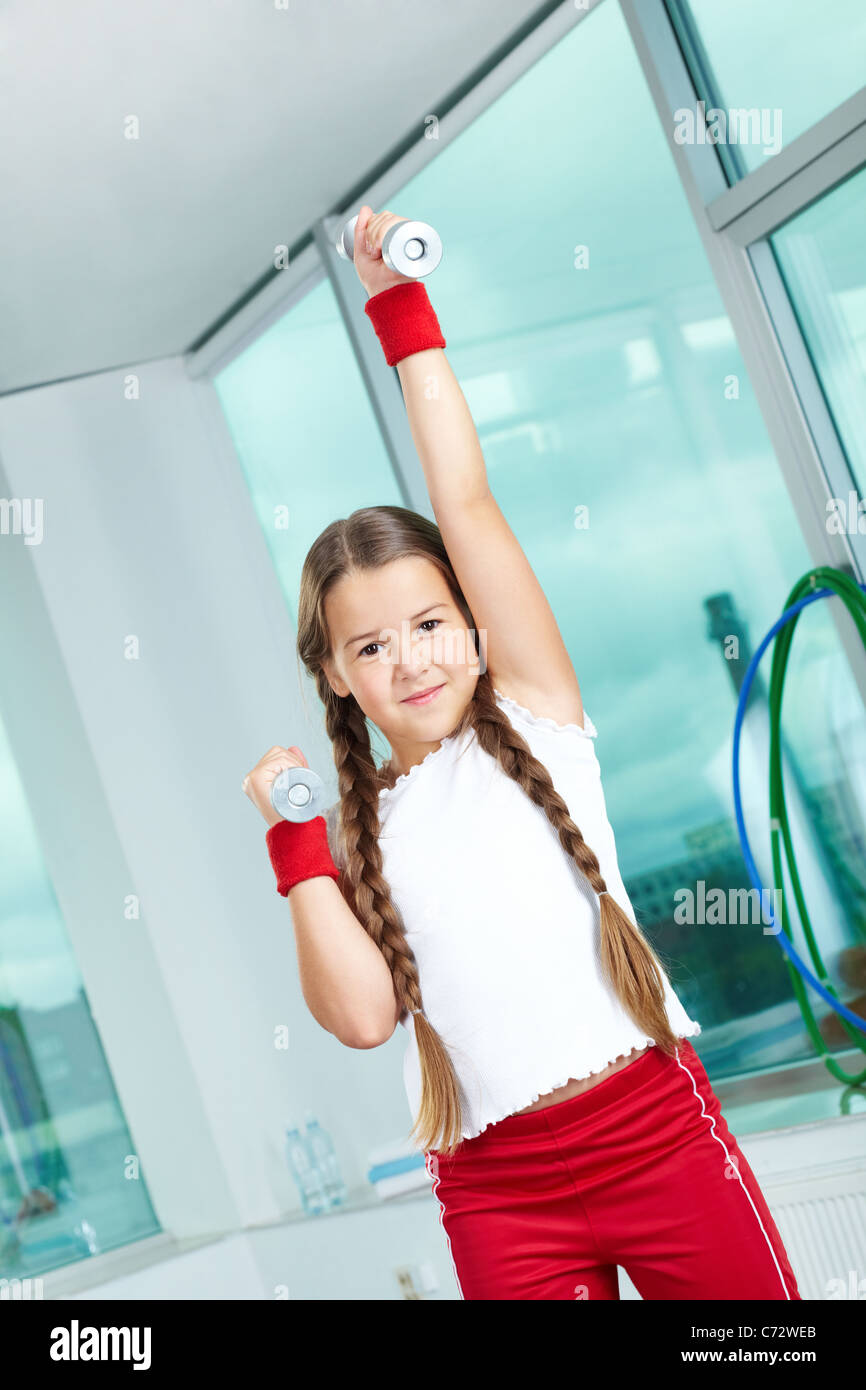 Portrait of healthy girl practicing physical exercise in gym Stock ...