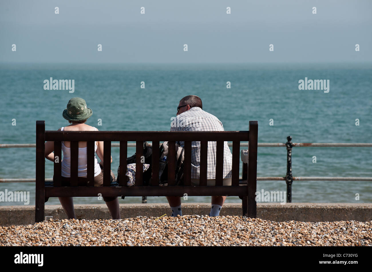 Two people sitting on a bench on the seafront at Kingsdown in Kent ...