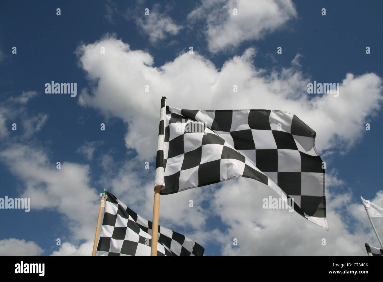 grand prix chequered flags flying in wind and blue sky Stock Photo - Alamy