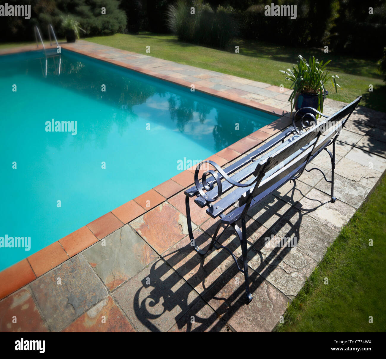 Bench beside a swimming pool Stock Photo - Alamy