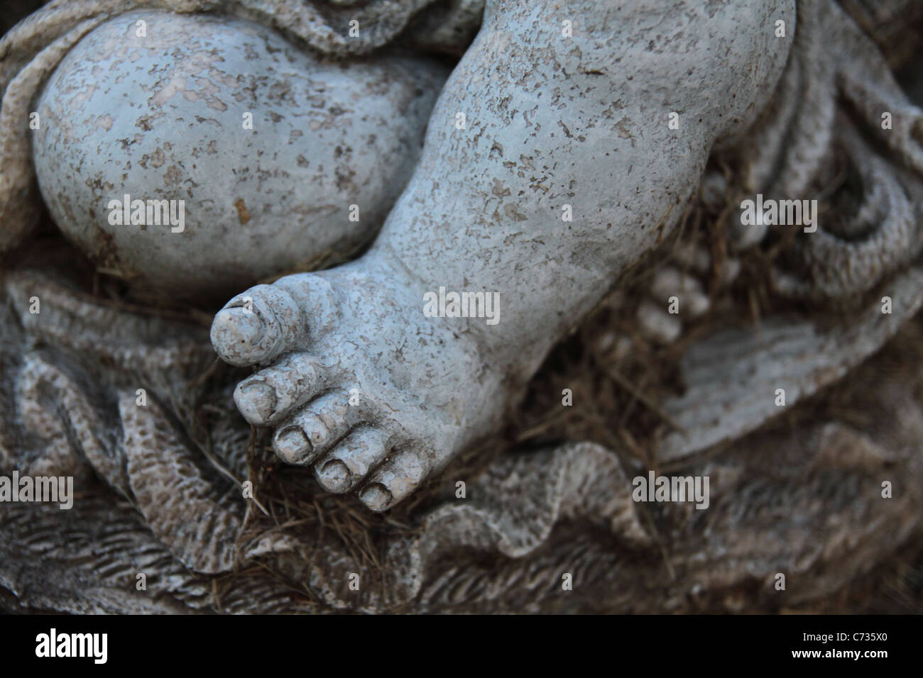 A close up of the feet on a statue of a baby Stock Photo - Alamy