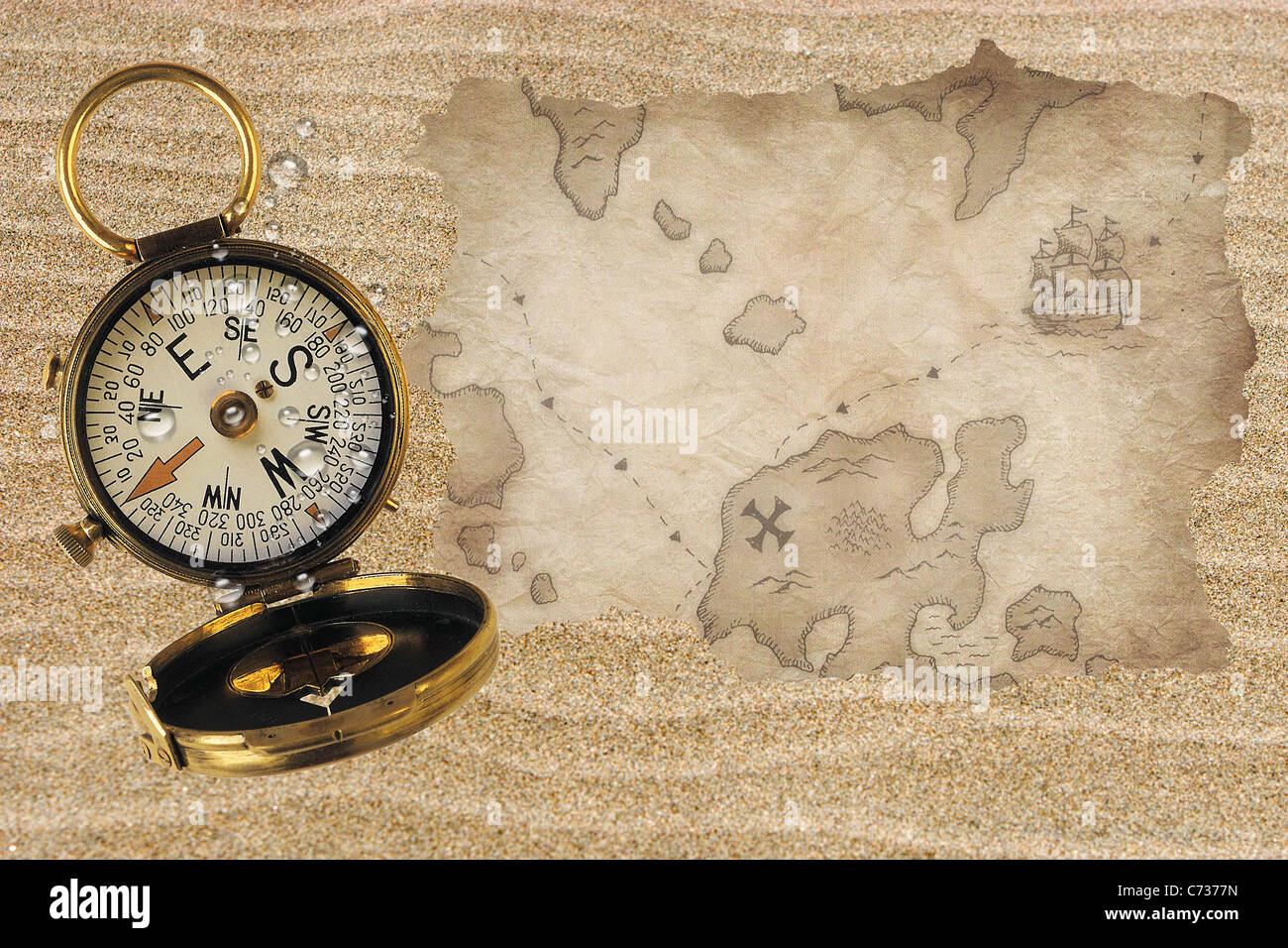 Treasure map and compass on sand Stock Photo - Alamy
