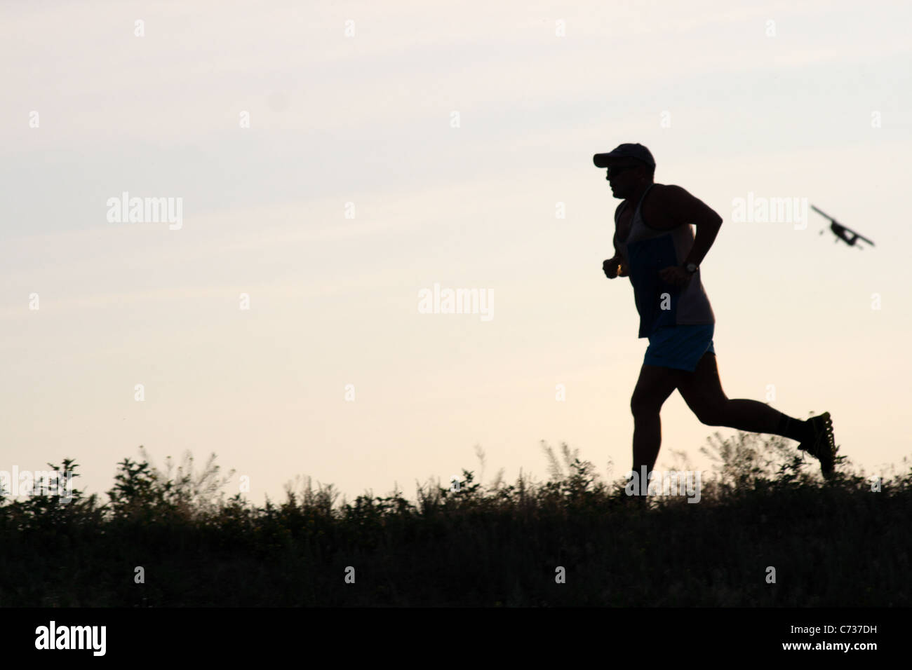silhouette of running man on the background of sunset sky Stock Photo ...