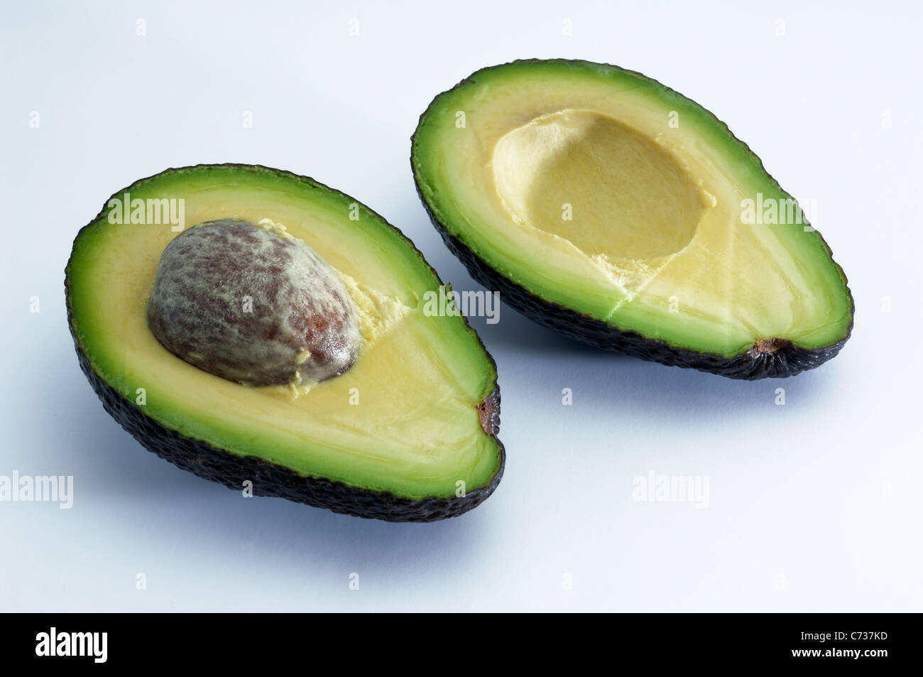 Avocado (Persea americana), halved fruit with kernel. Studio shot ...