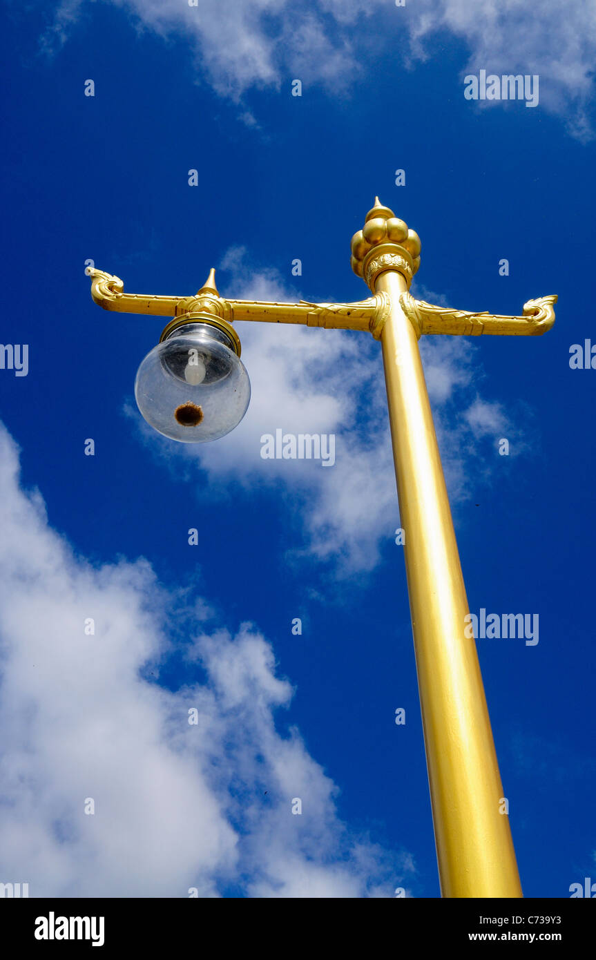 a gold-colored lamp post standing in the blue sky Stock Photo - Alamy