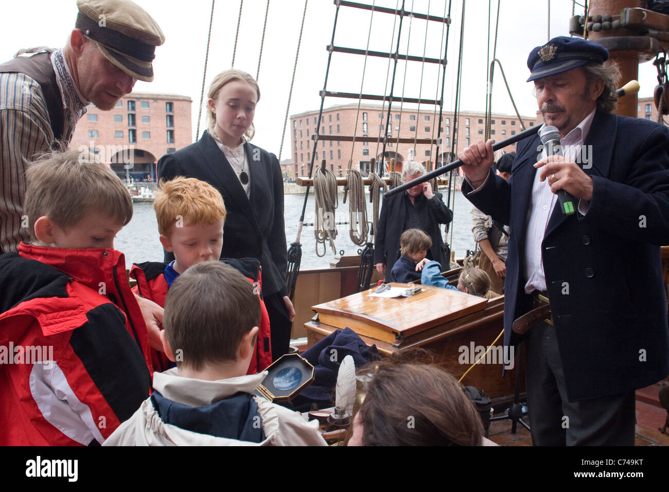 Captain showing children how to read a compass as part of visit to tall ...