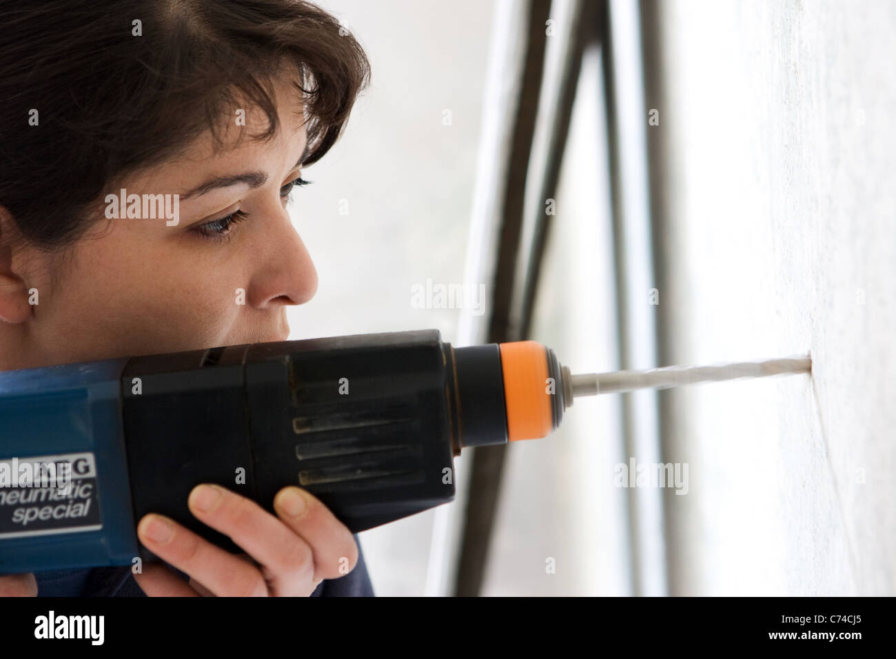 A woman drilling with a drill Stock Photo - Alamy