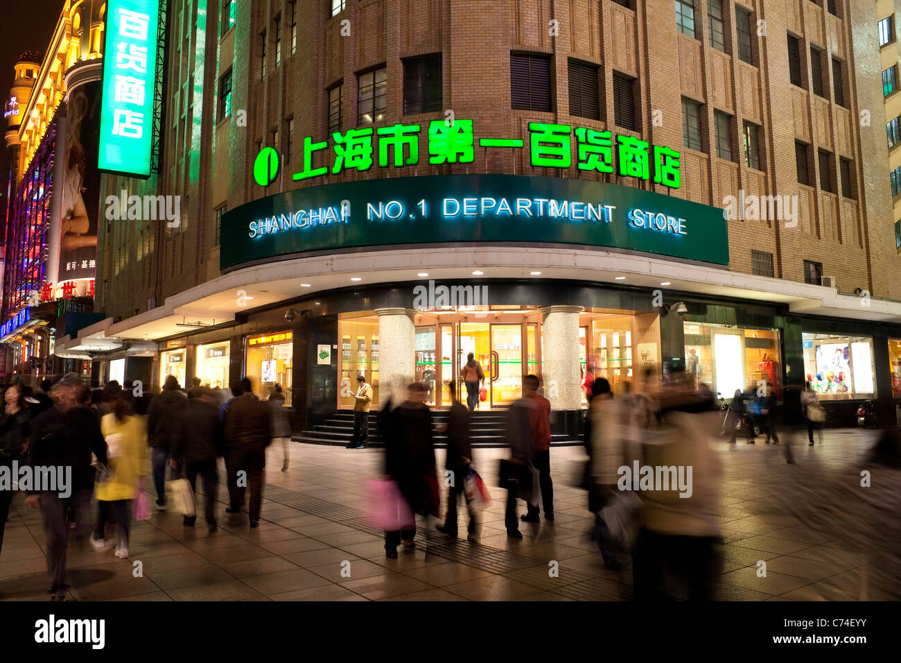 Pedestrians at night walking past stores on Nanjing Road, Shanghai ...