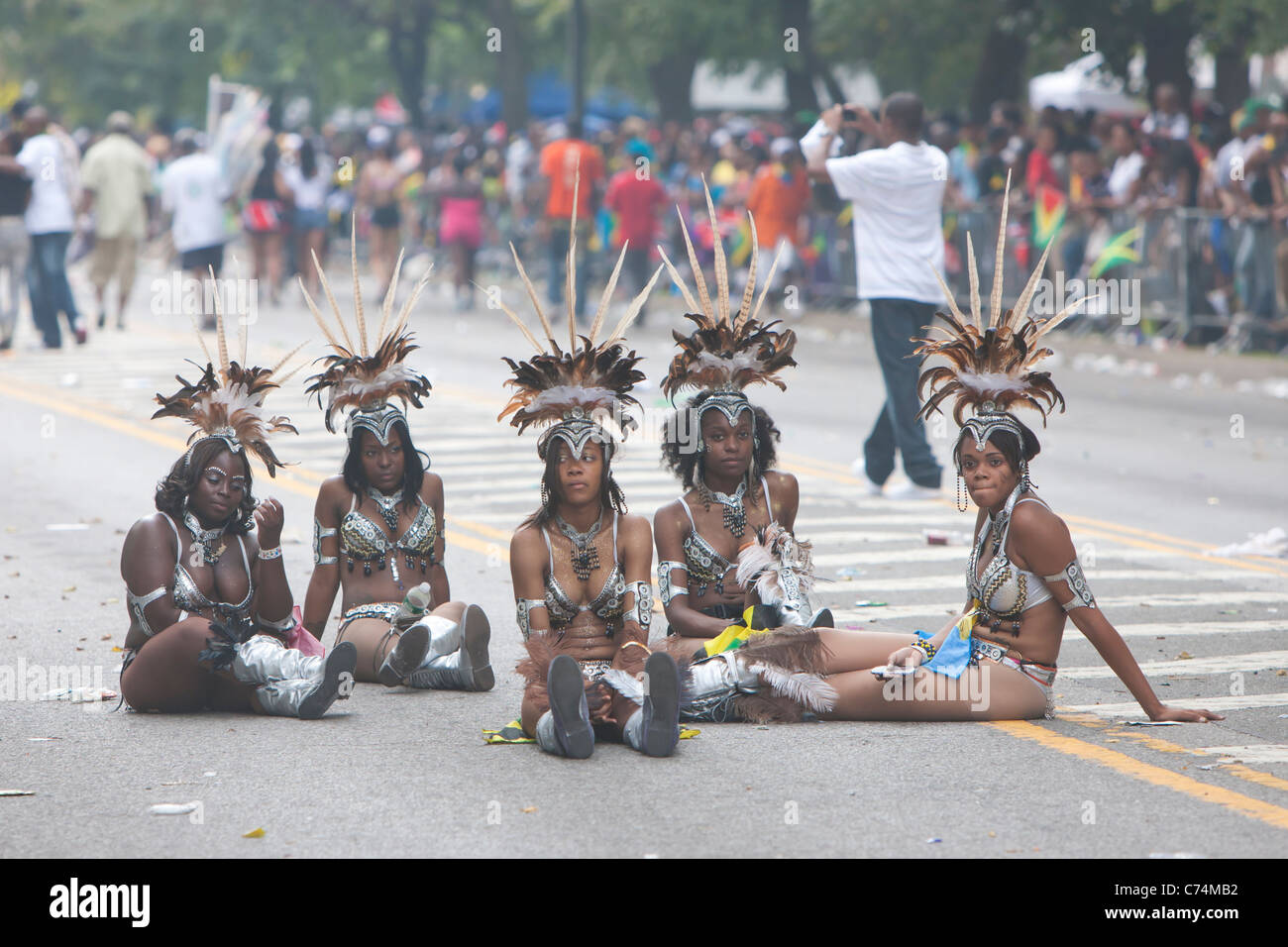 Parade participants in festive attire take a break at the West Indian ...