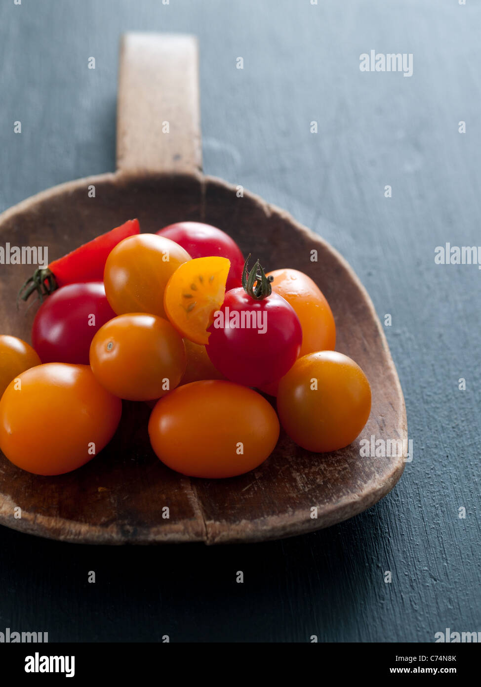Cherry tomatoes in a rustic wooden spoon Stock Photo - Alamy
