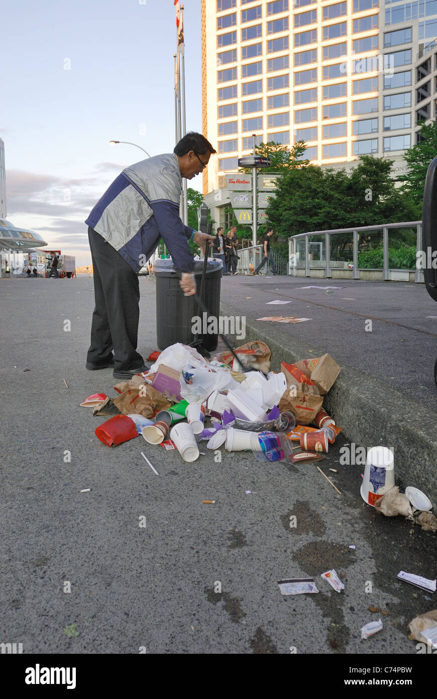 Man cleaning garbage that was thrown into the streets of Vancouver City ...