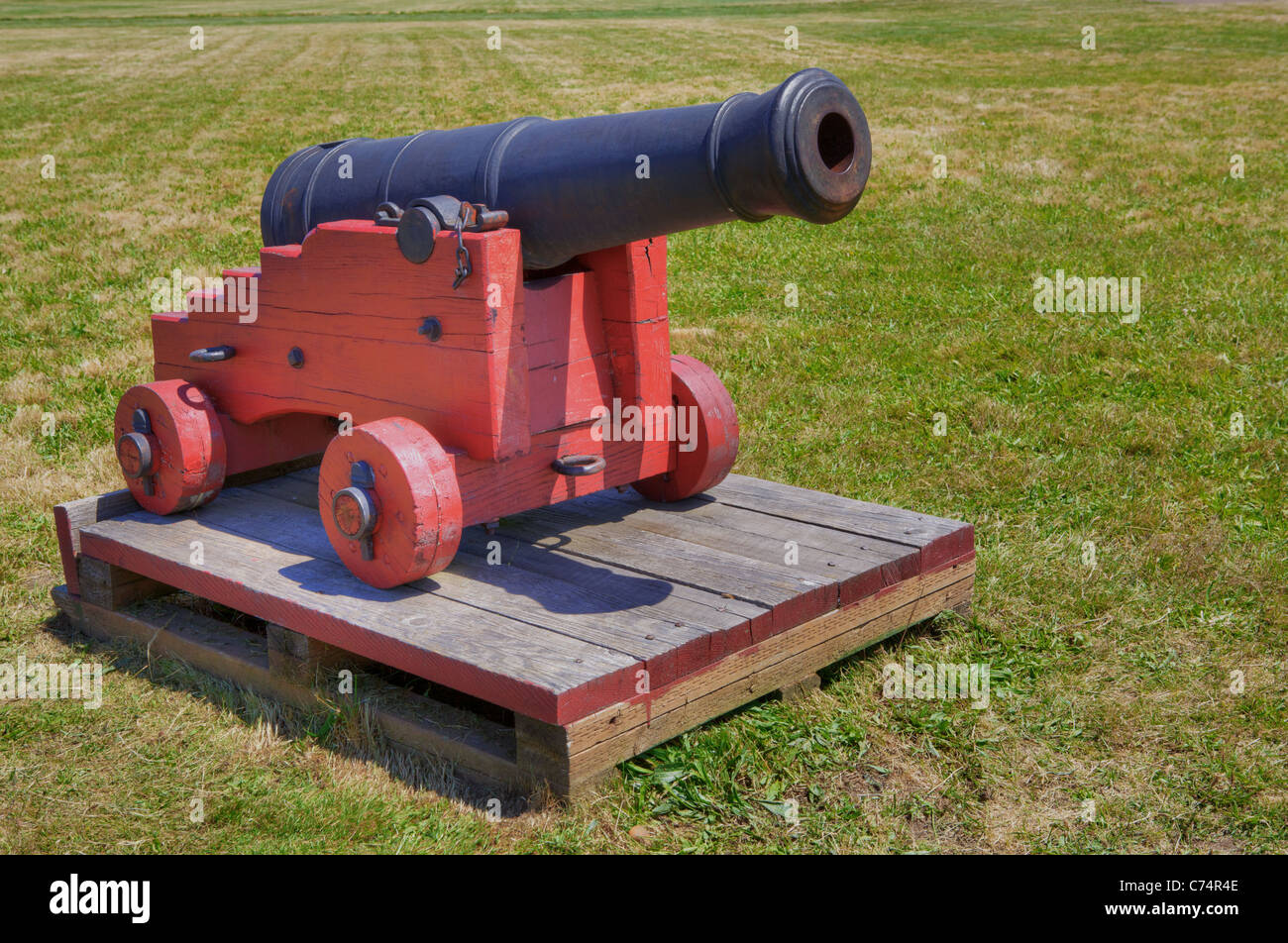 Small Black Field Cannon on a red support sitting on a grass field done ...