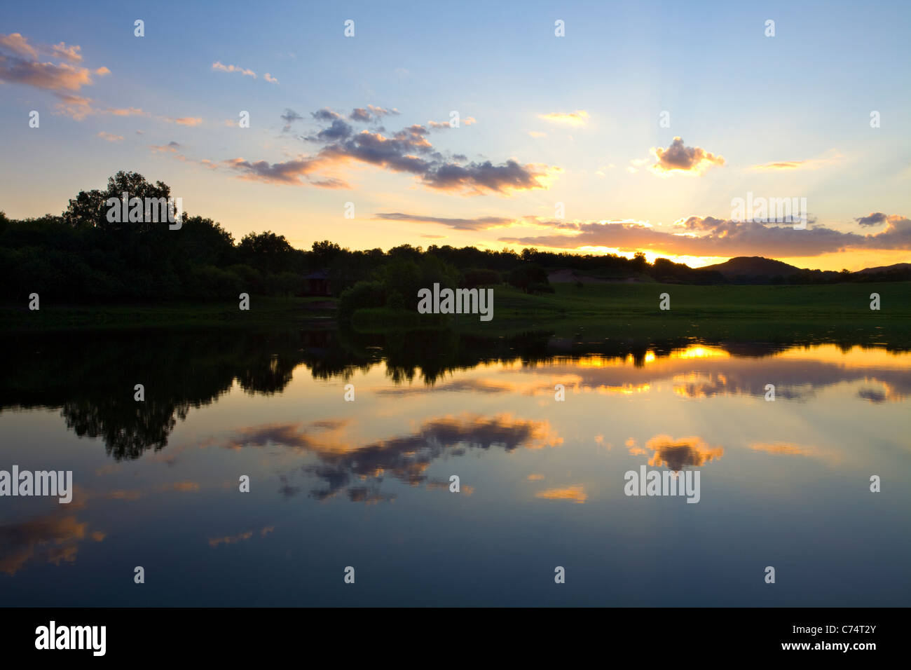 Sun rising over a small lake Stock Photo - Alamy