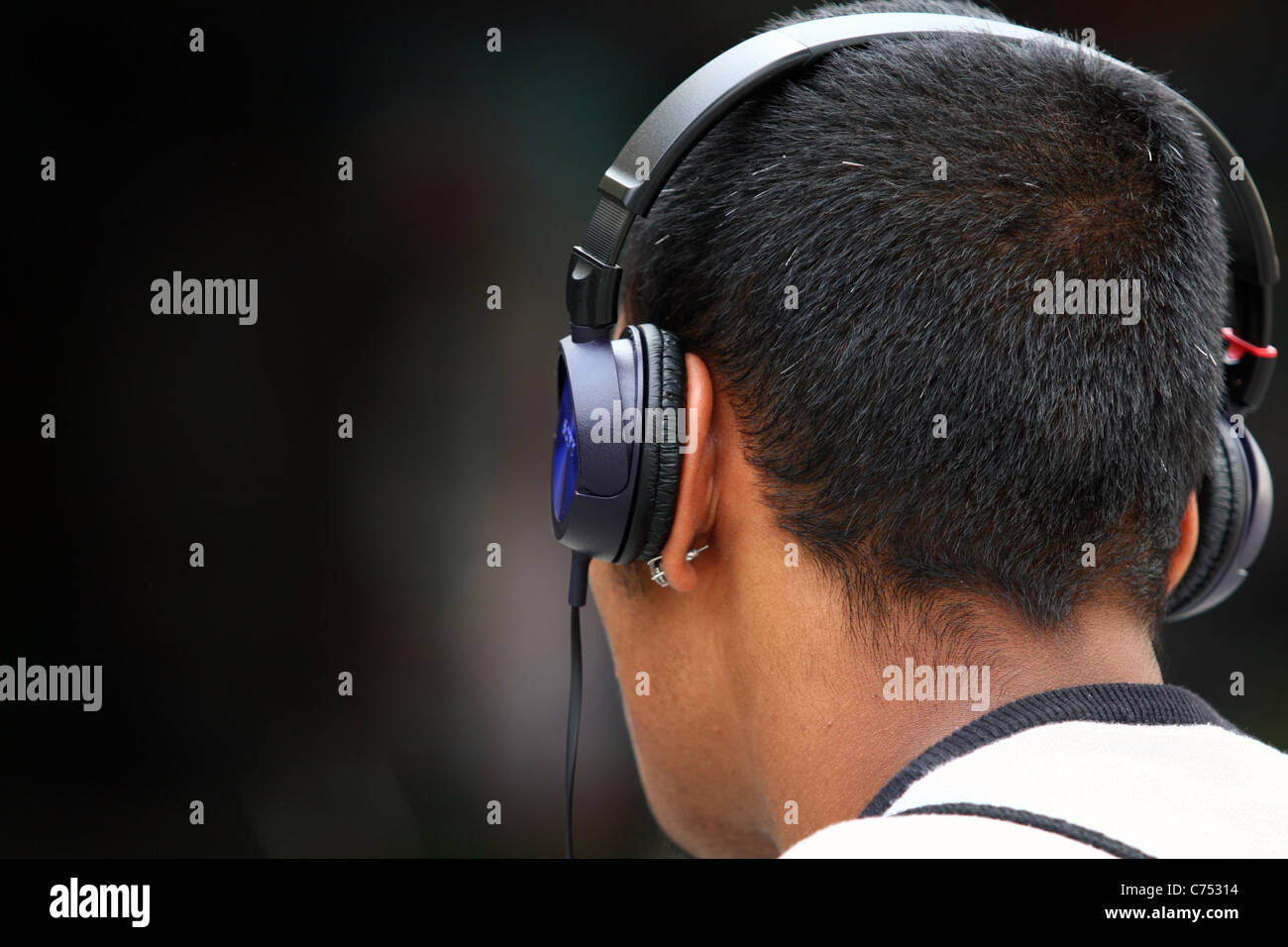 The rear view of a man wearing headphones in a street Stock Photo - Alamy