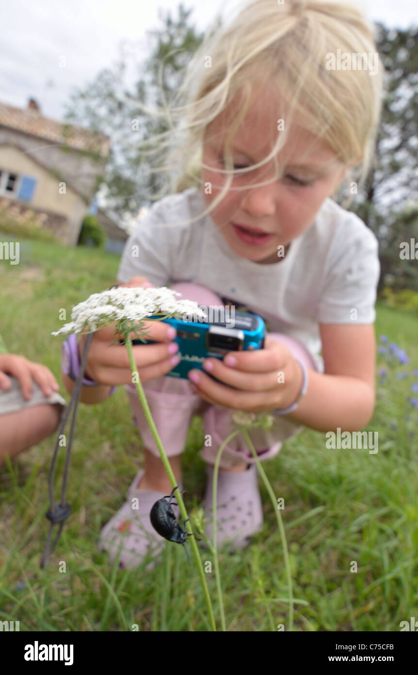 KIds enjoying taking photographs of bug and animals in a field Stock ...