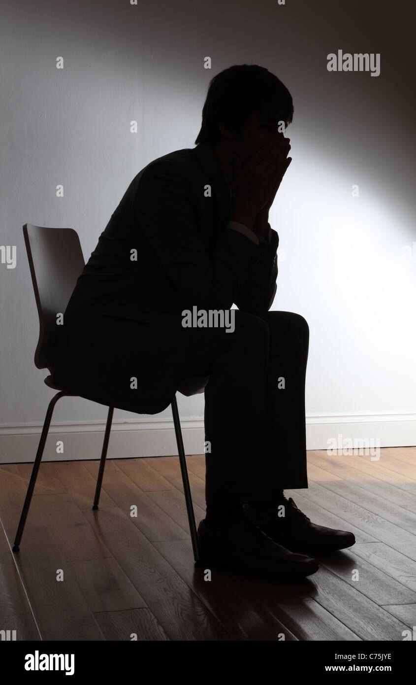 Silhouette of a man sitting thinking Stock Photo - Alamy