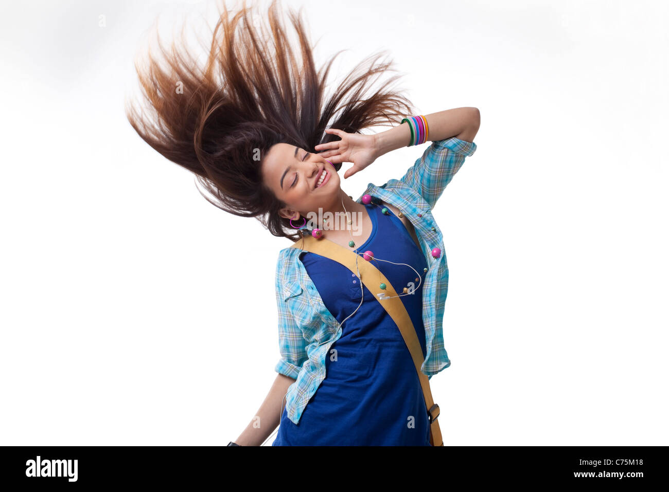 Young woman listening musing white spinning hair over white background ...