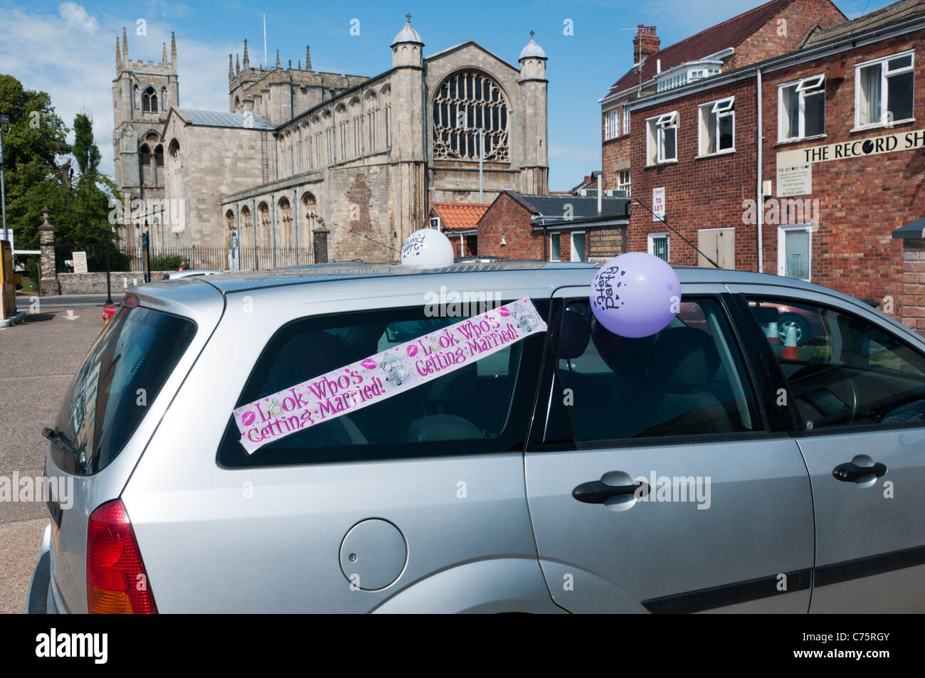 Poster on a wedding car with church in background Stock Photo - Alamy