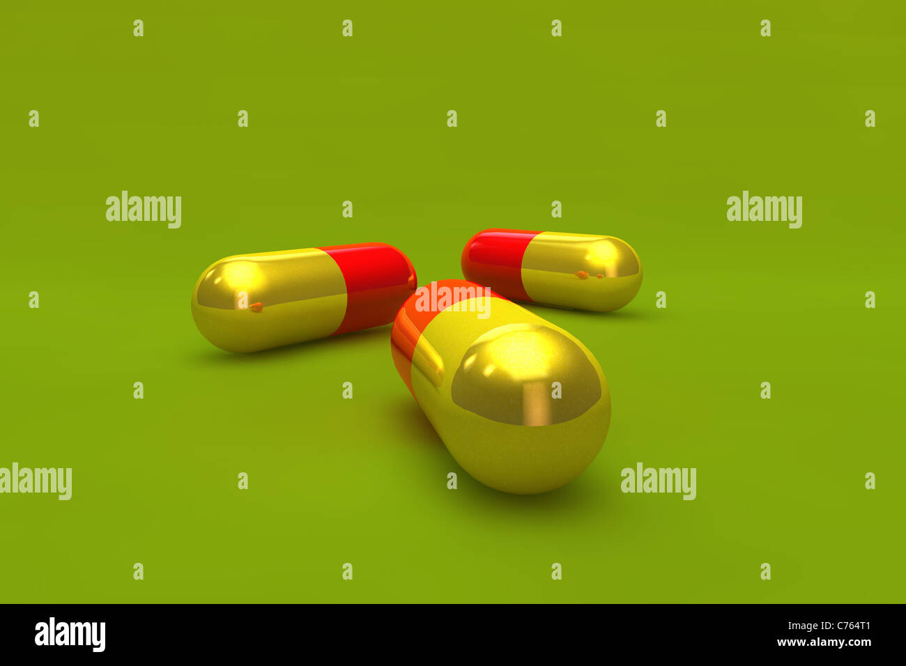 Golden capsules lying on green floor Stock Photo - Alamy