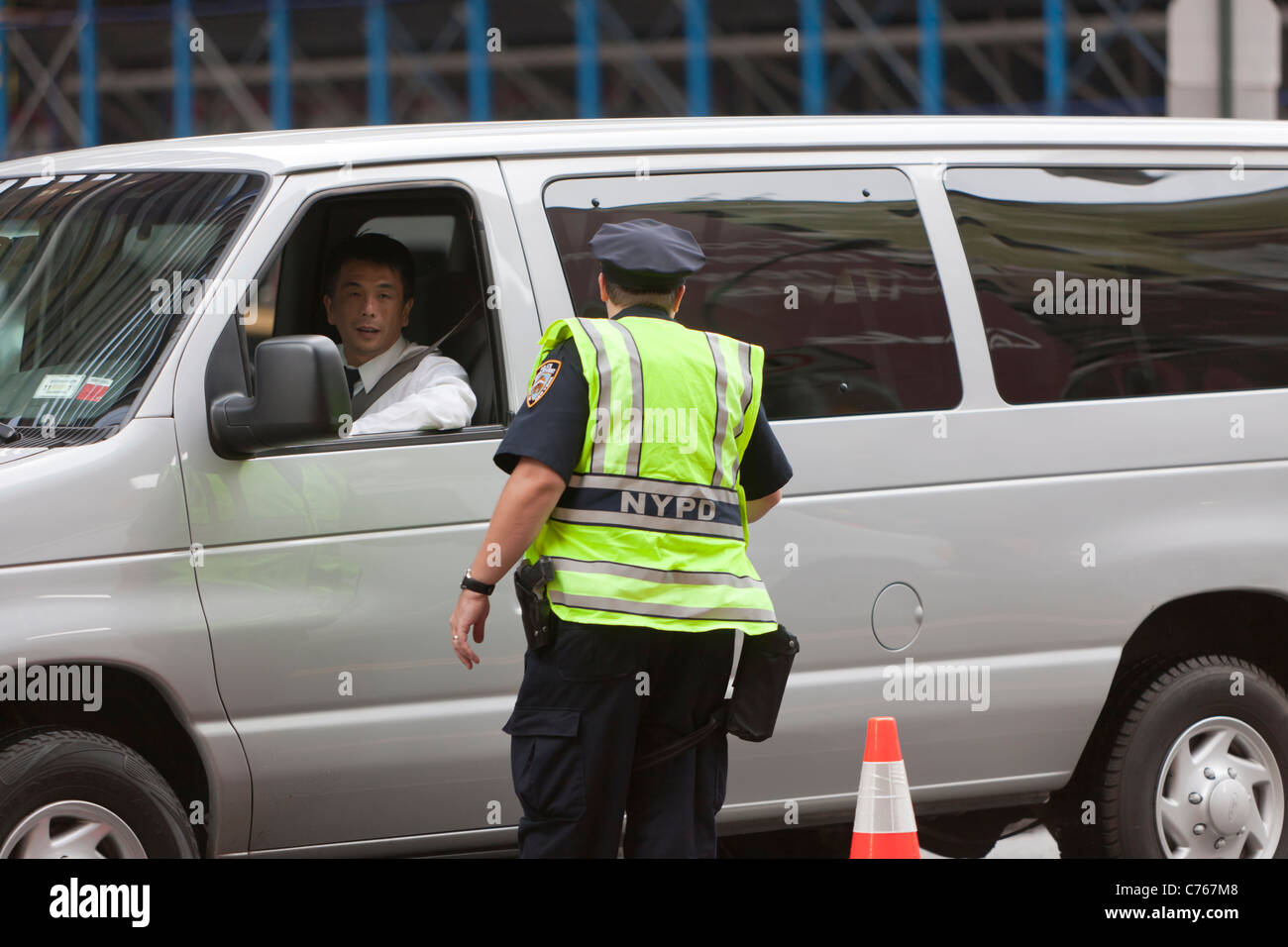A NYPD police officer screens vehicle as they pass through a security ...