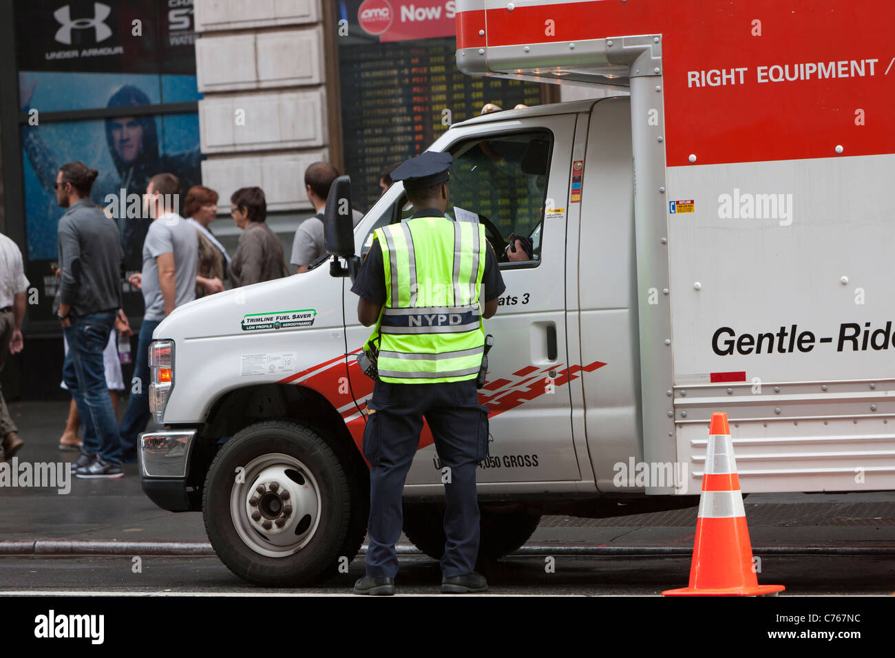 A NYPD police officer checks a drivers identification at a security ...