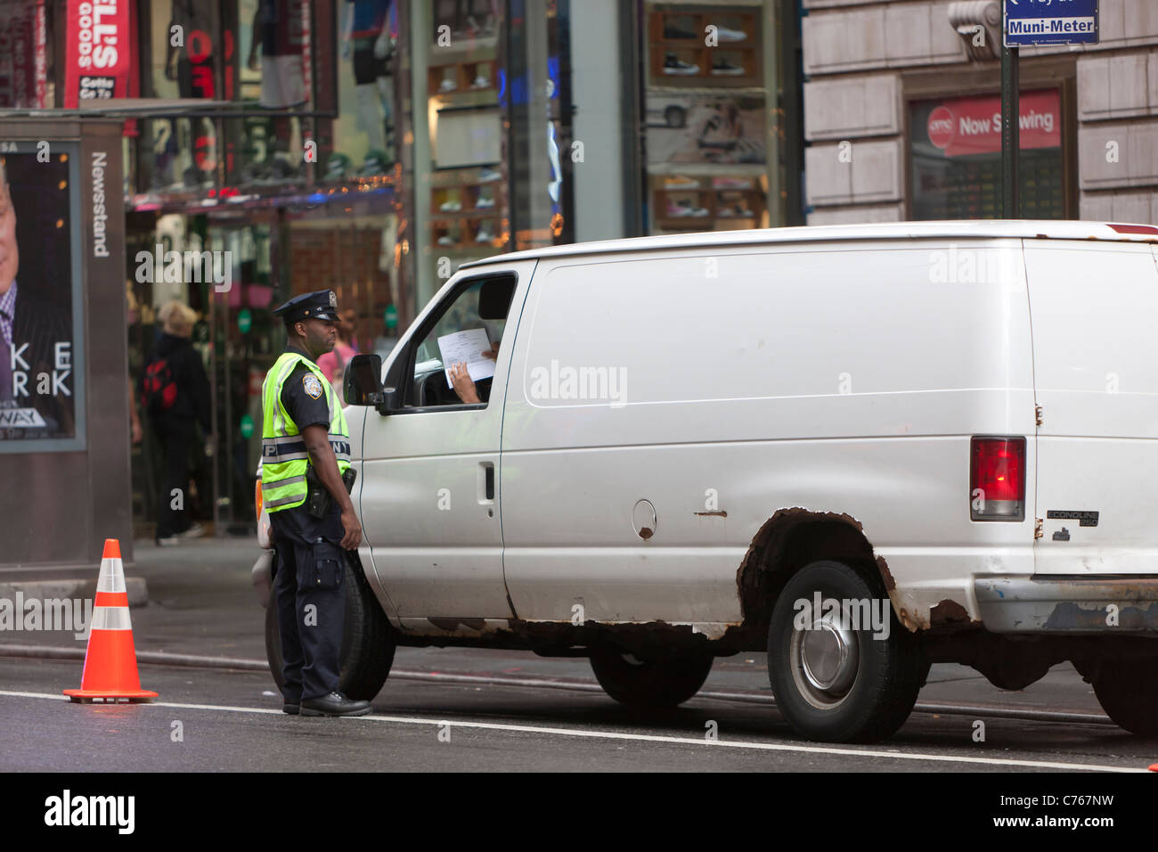 A NYPD police officer checks a drivers identification at a security ...