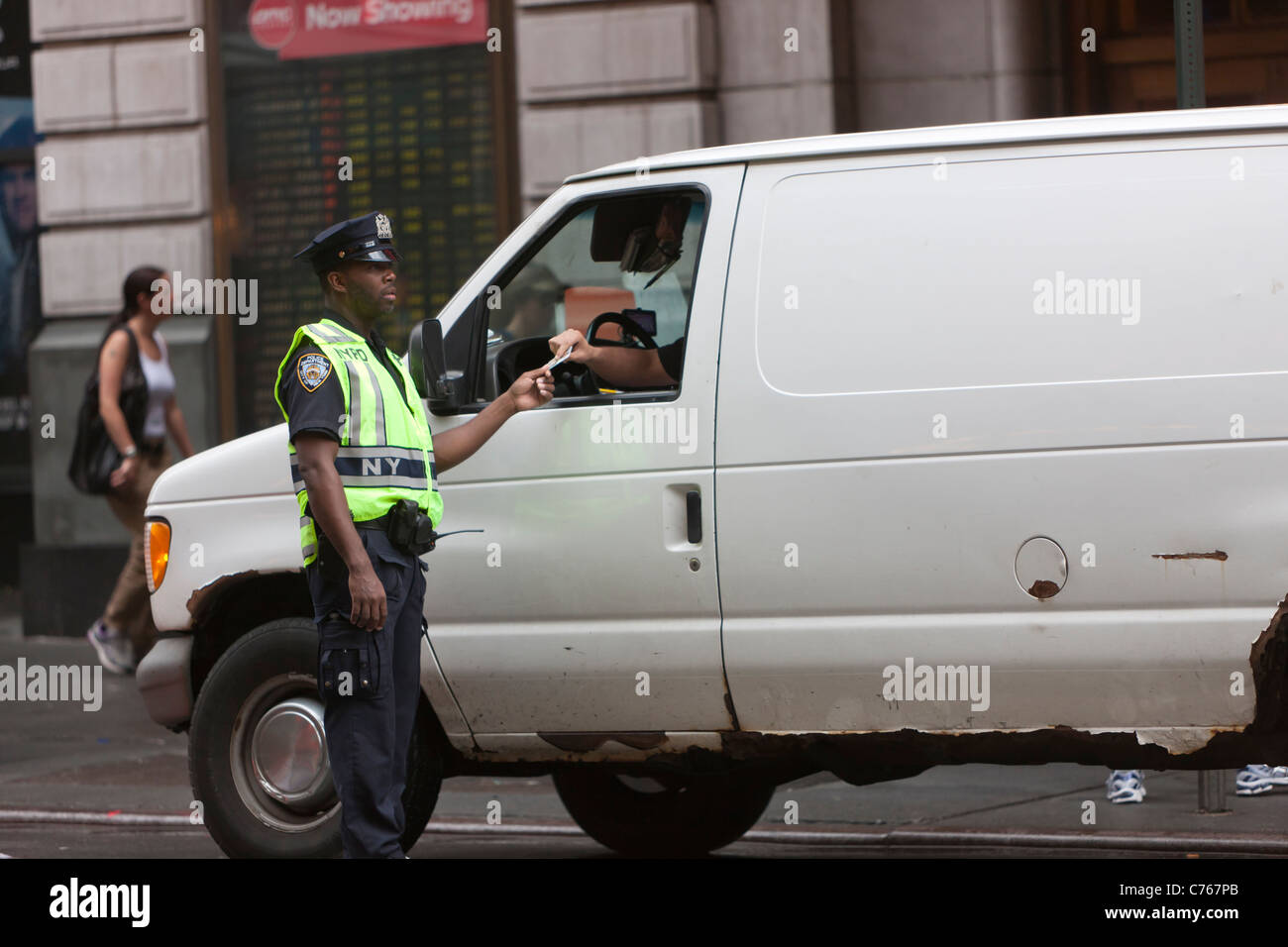 A NYPD police officer checks a drivers identification at a security ...