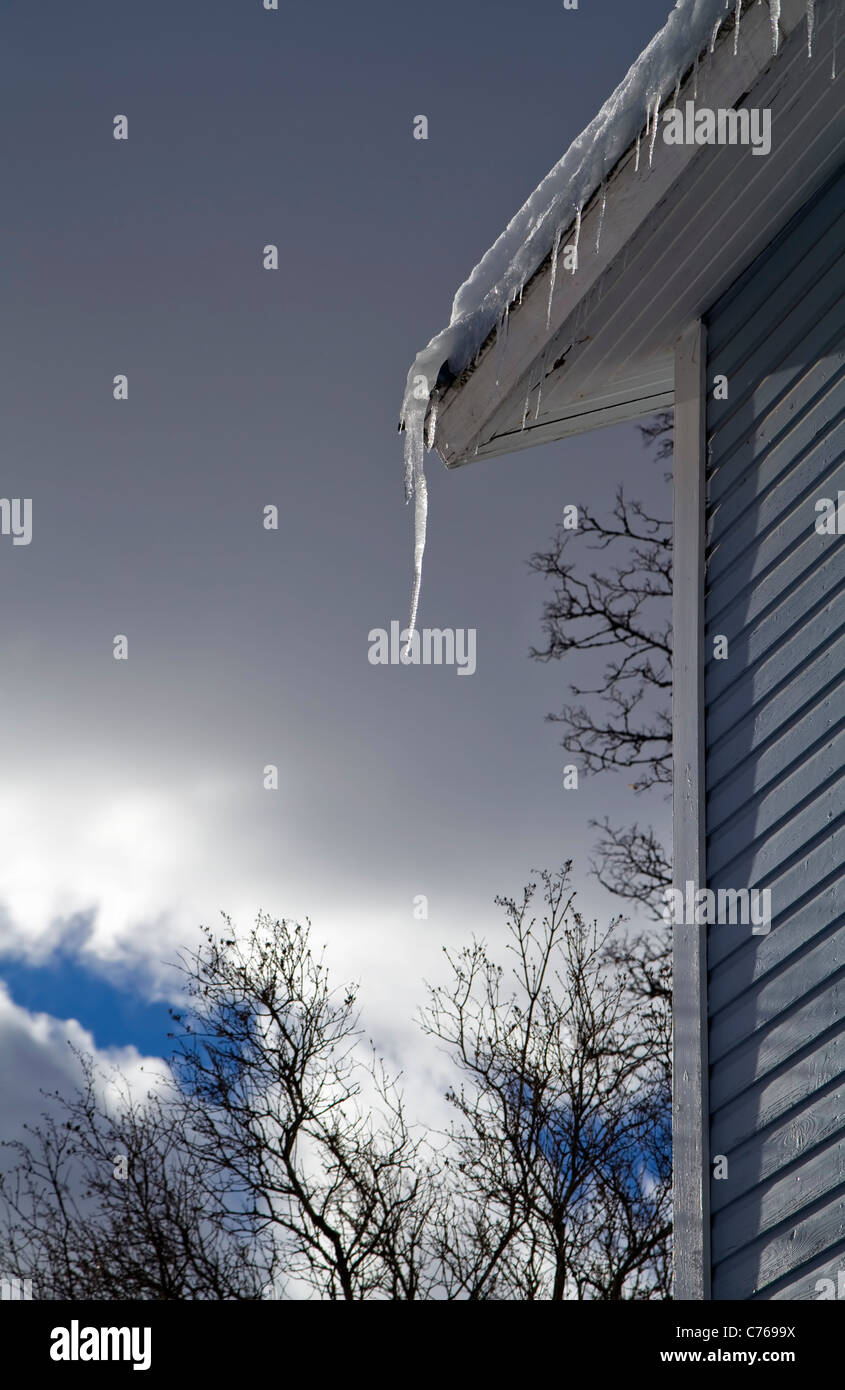 Icicles hanging from eave Stock Photo - Alamy