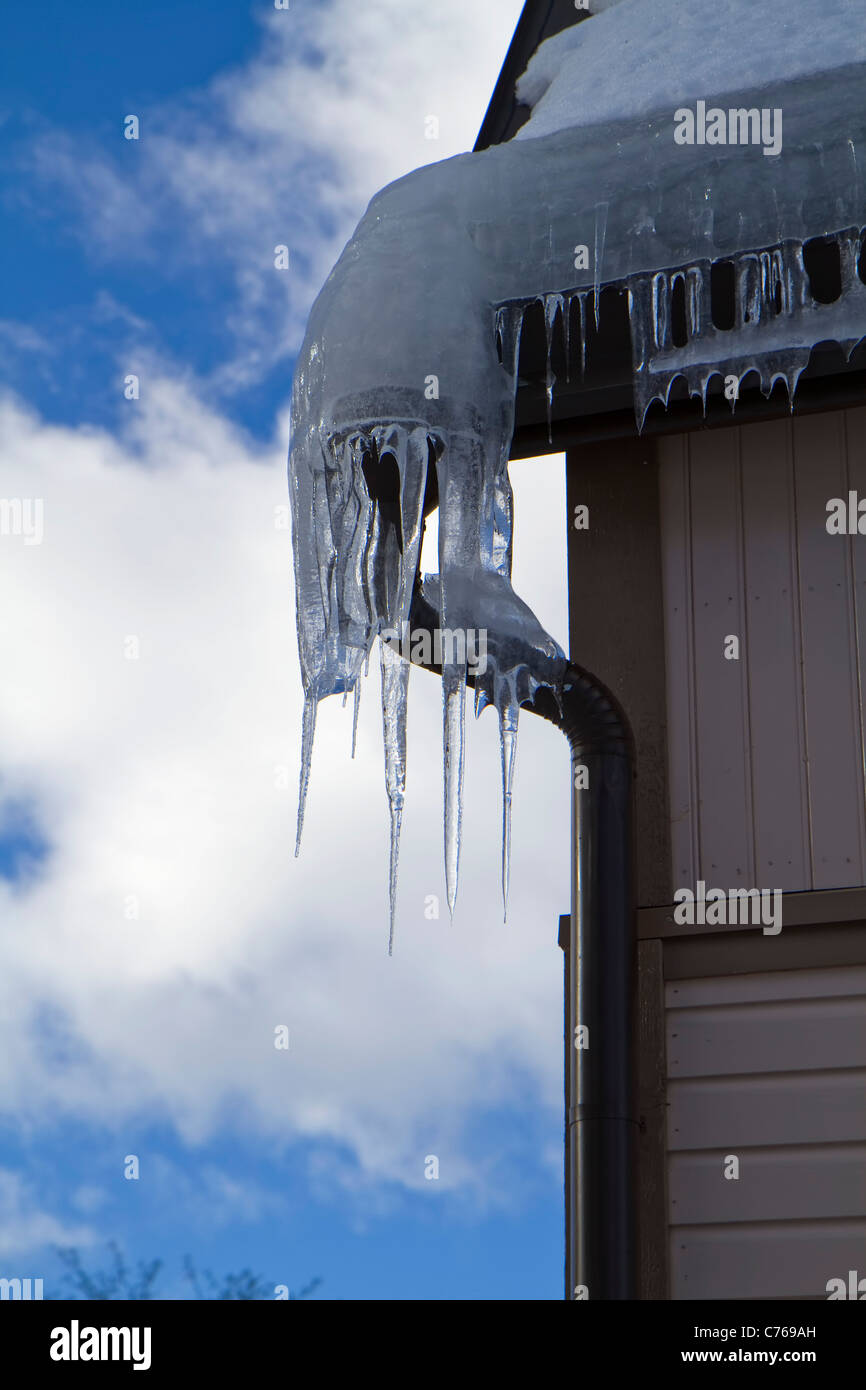 Icicles hanging from eave Stock Photo - Alamy