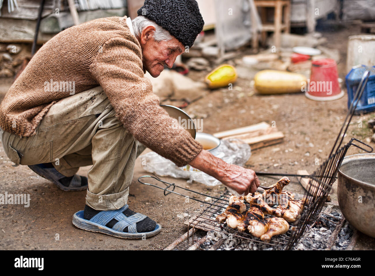 Old man outdoor making a grill with chicken drumsticks Stock Photo - Alamy