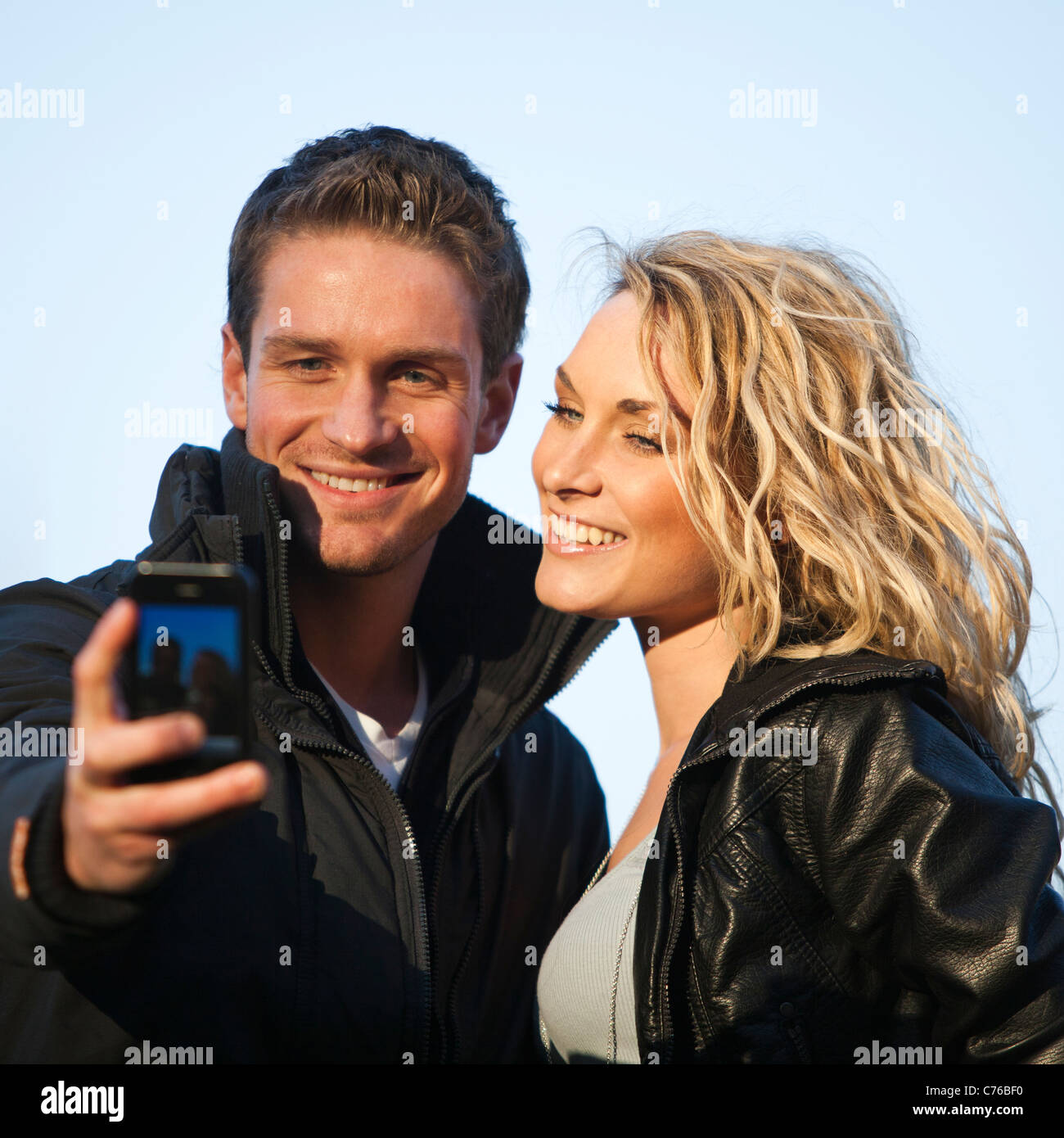 UK, London, Young couple taking picture using smartphone Stock Photo ...