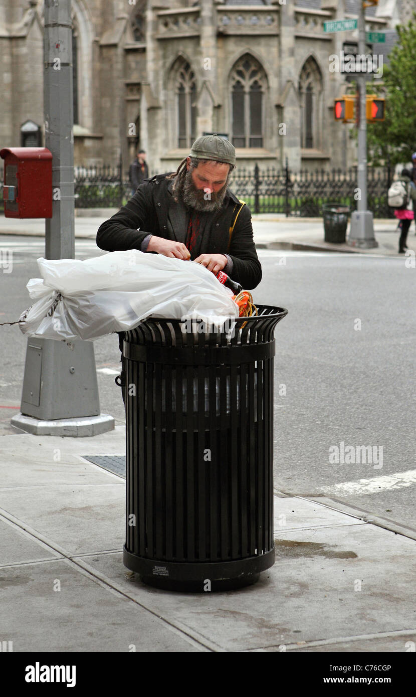 A homeless man rummaging through garbage New York City USA Stock Photo ...