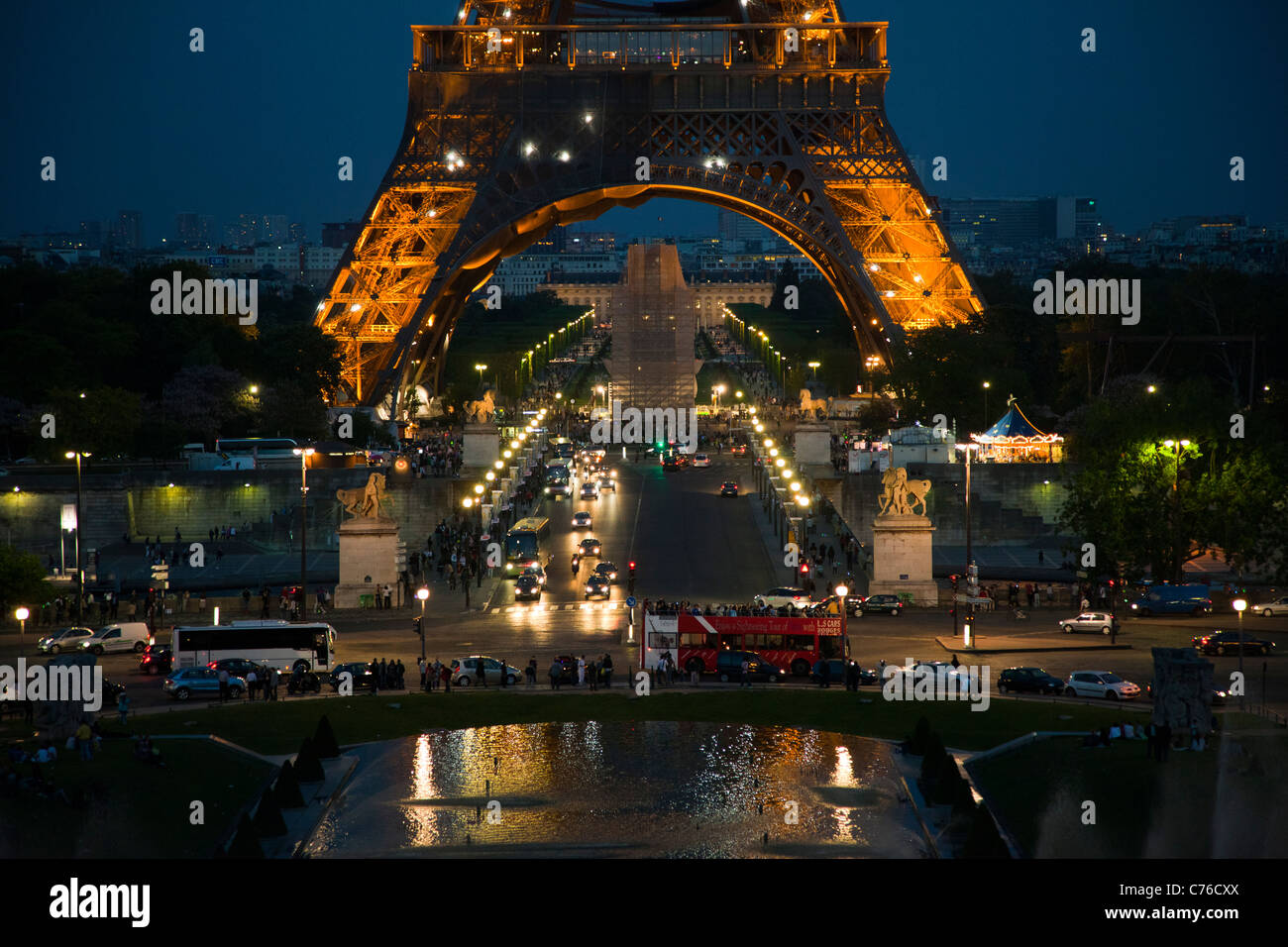 France, Paris, Traffic on avenue and Eiffel Tower illuminated at night ...
