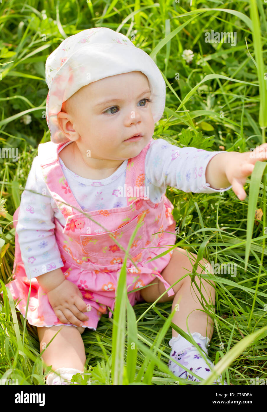 Curious baby girl on grass Stock Photo - Alamy