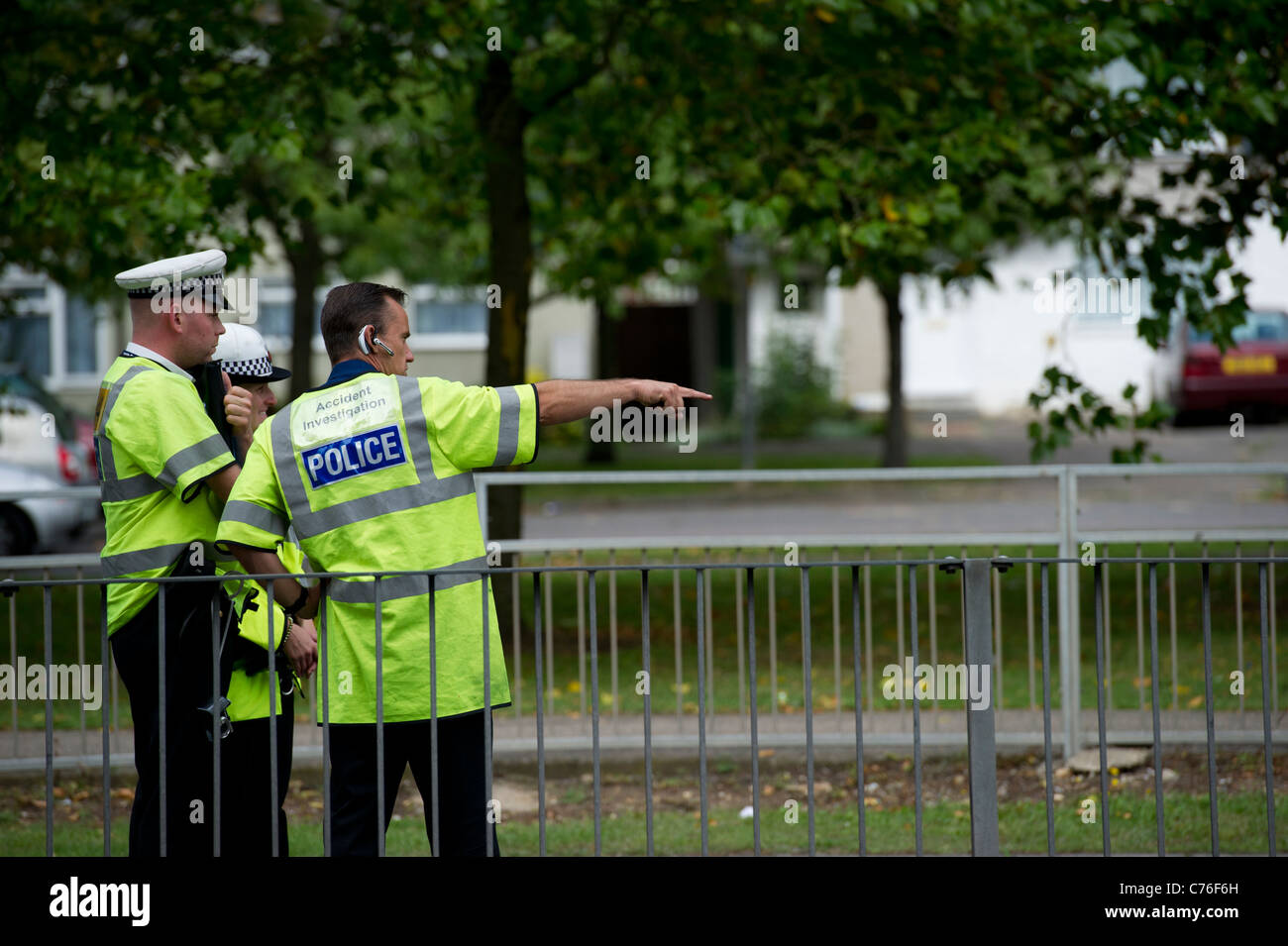 Three police officers discussing the scene of a serious road traffic ...