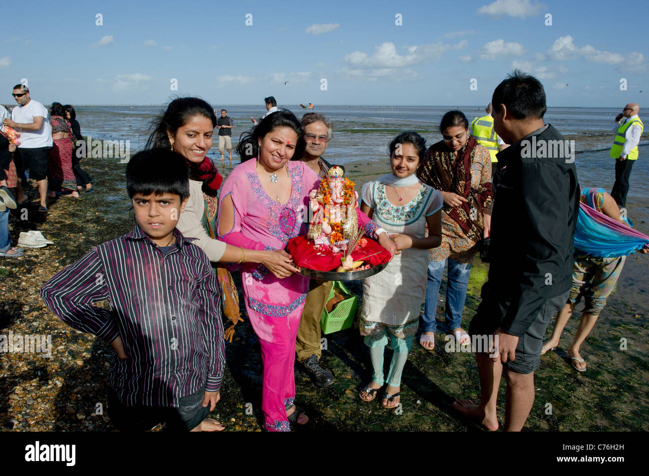 A Hindu family holding a statue of the Hindu God, Lord Ganesh at the ...