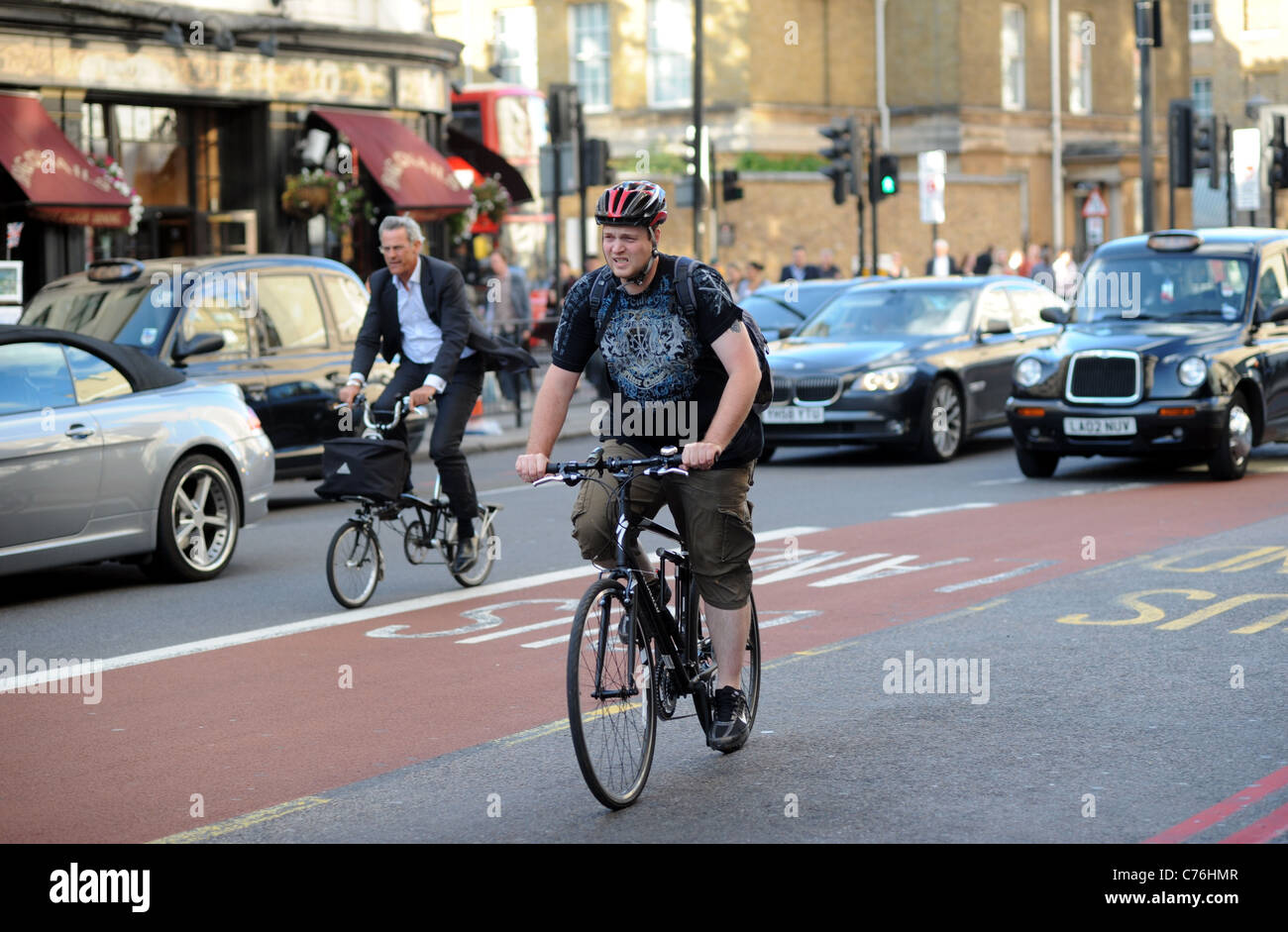 Cyclists in rush hour traffic near Buckingham Palace London UK Stock ...