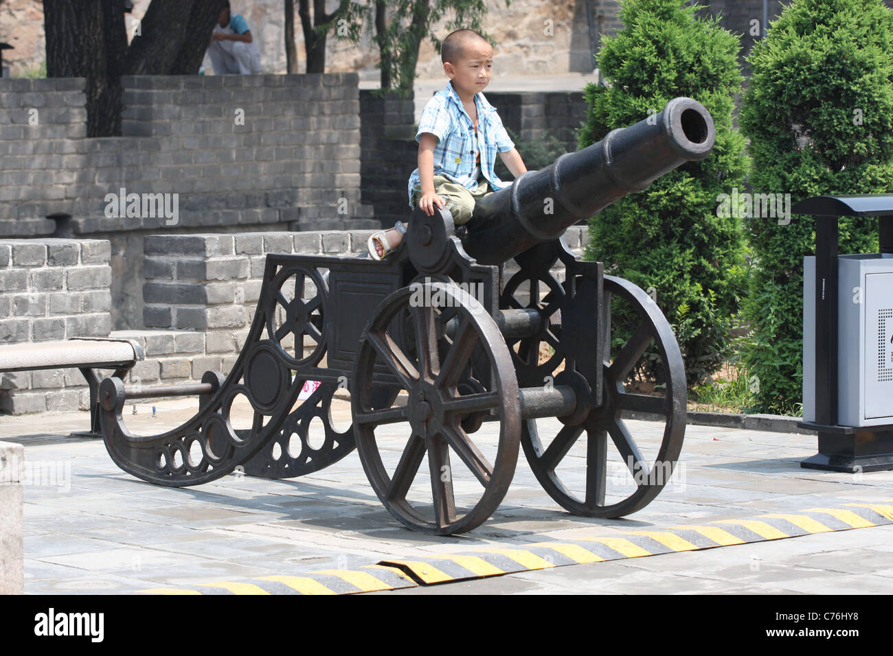 Small boy sitting on an old wheel mounted cannon near the ticket office ...