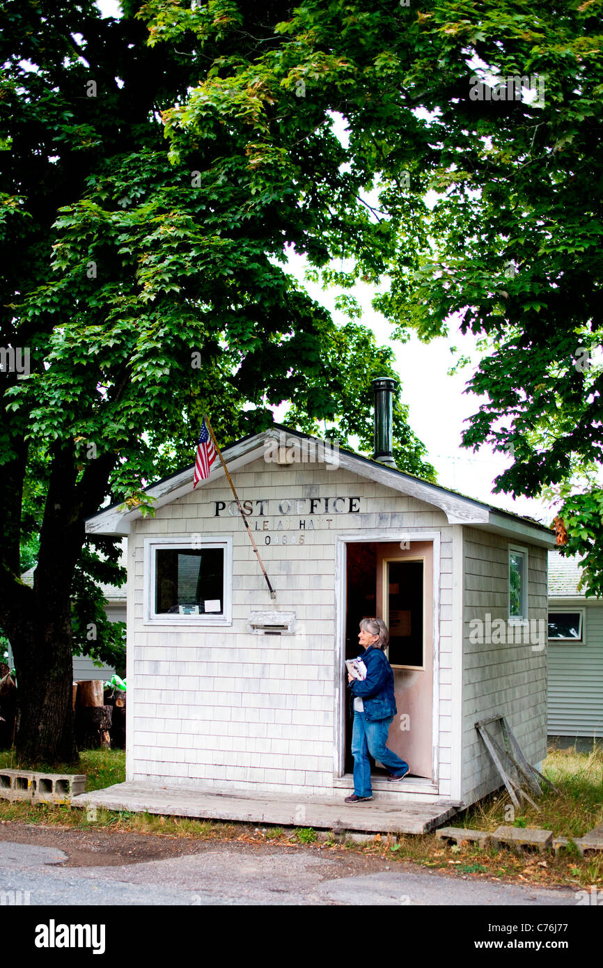 A woman walks out of a small building after getting her mail Stock ...