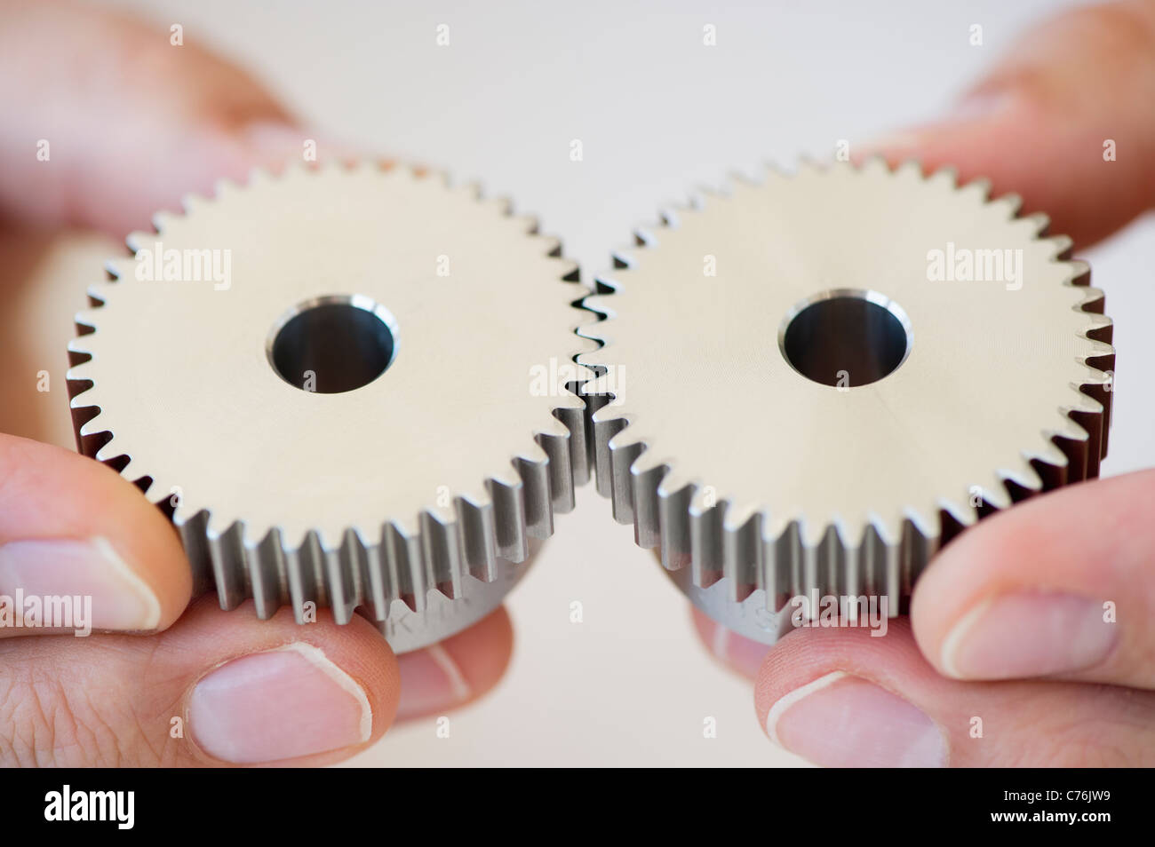 Hands holding gears Stock Photo - Alamy