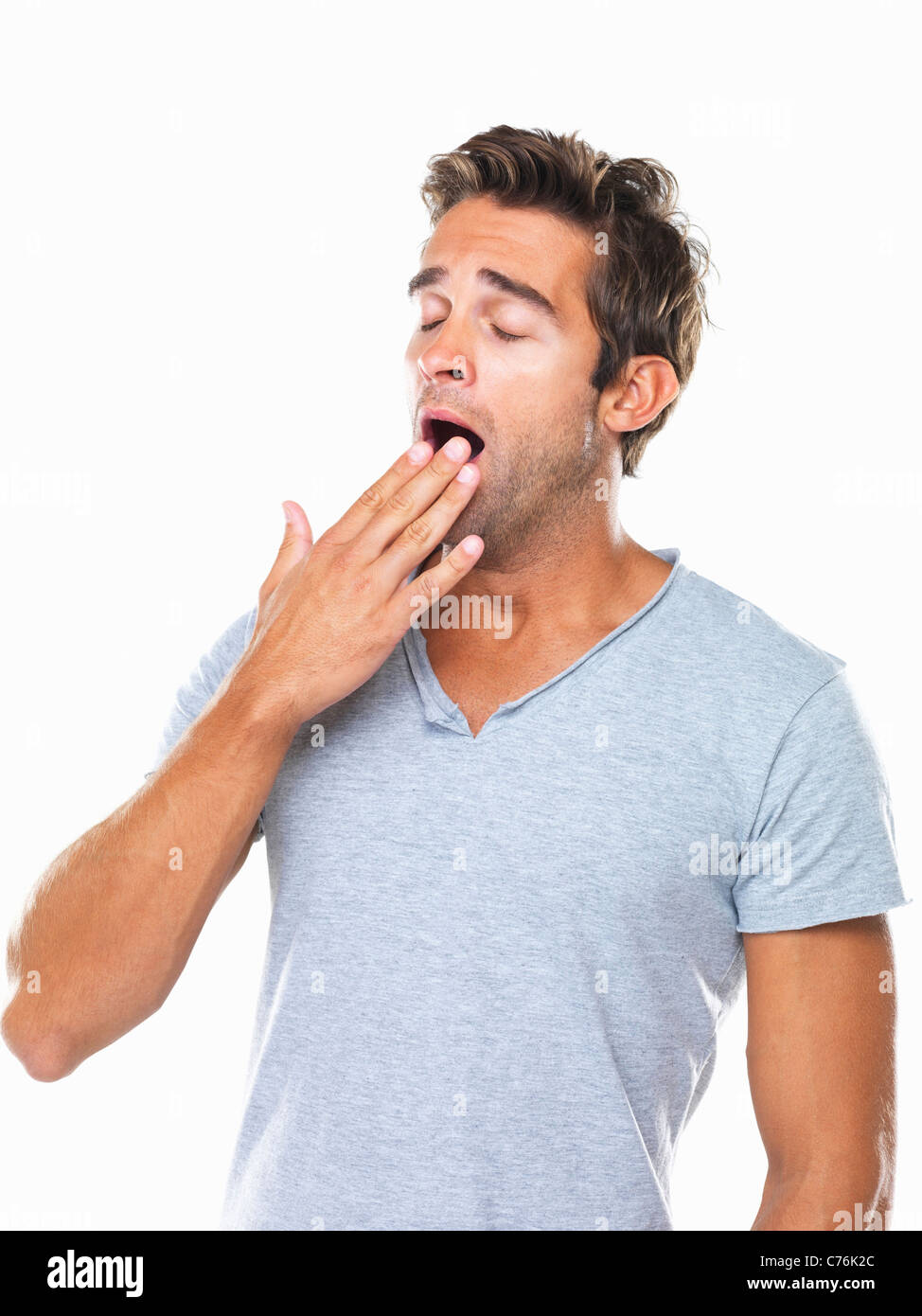 Studio portrait of young man yawning Stock Photo - Alamy
