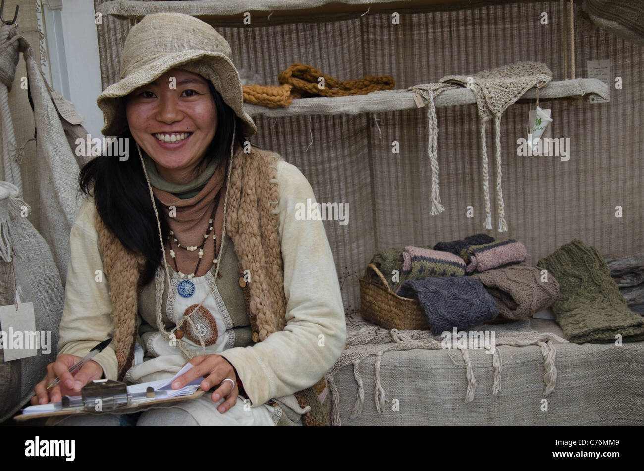 A lady looking after a market stall at a festival with a clipboard ...