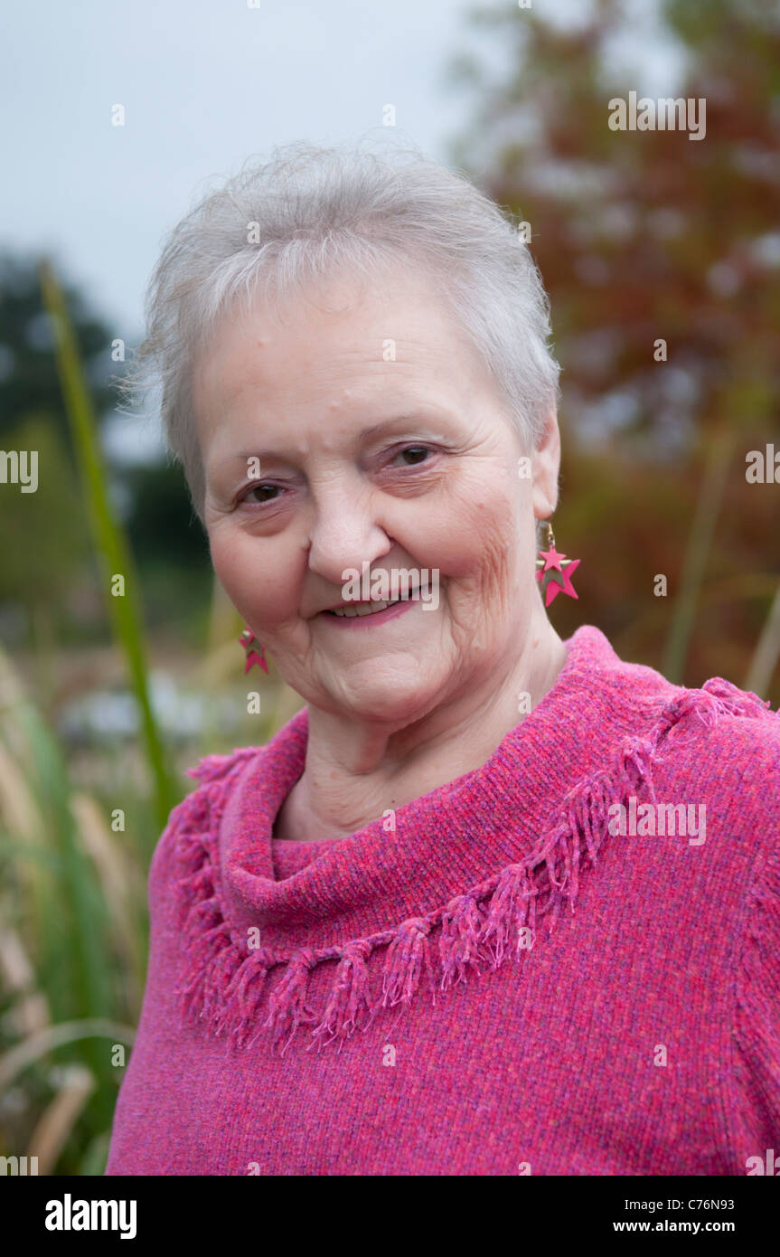Senior women in a pink sweater Stock Photo - Alamy