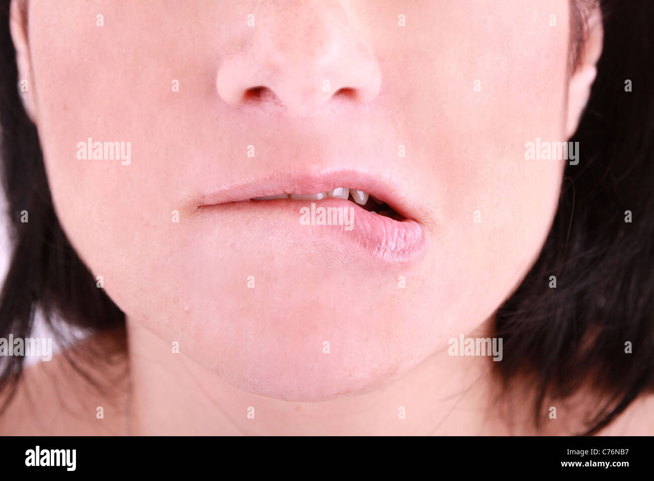 an embarrassed woman biting on her lip Stock Photo - Alamy